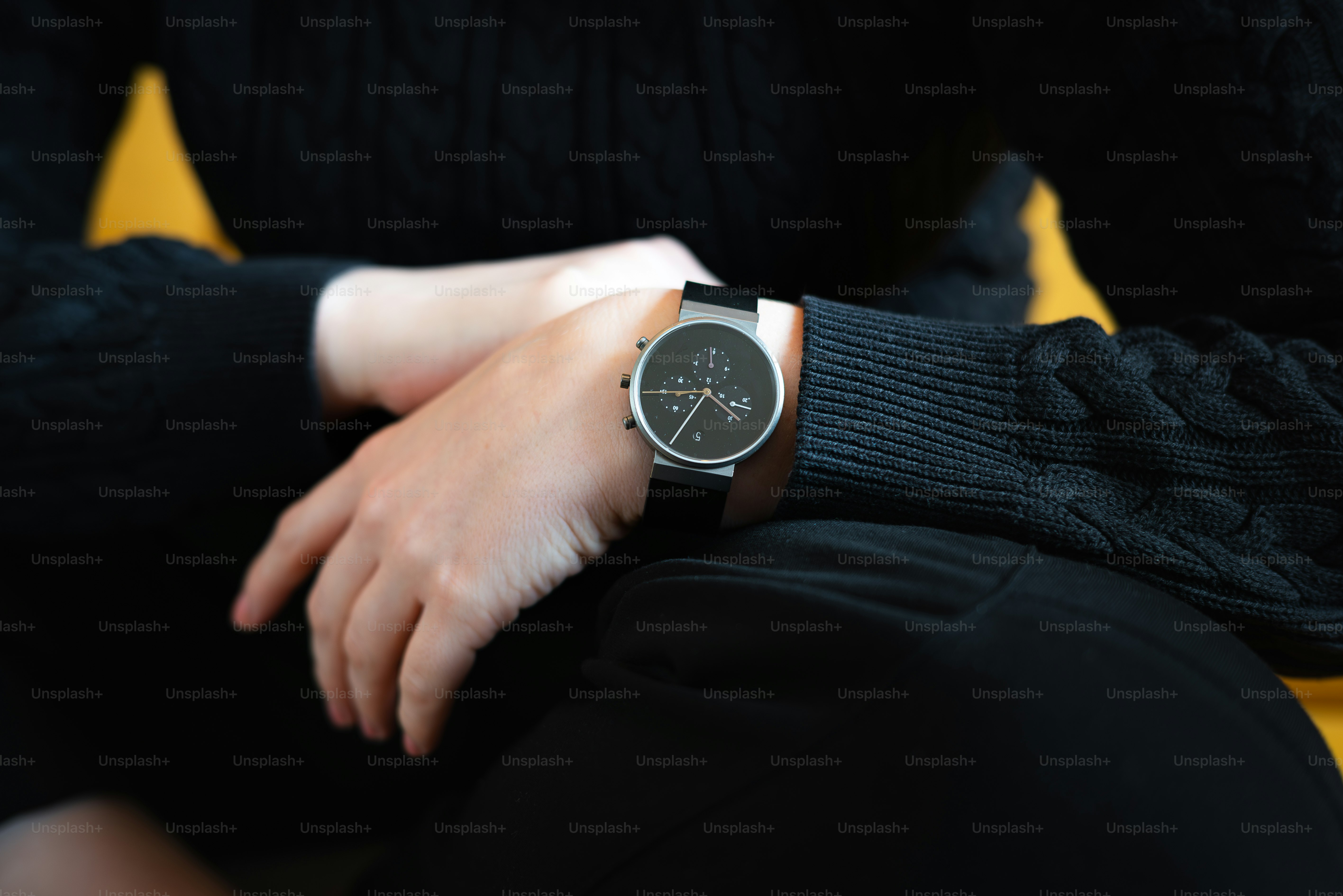 Una mujer con un reloj sentada en una silla foto – Imagen de Relojes en ...