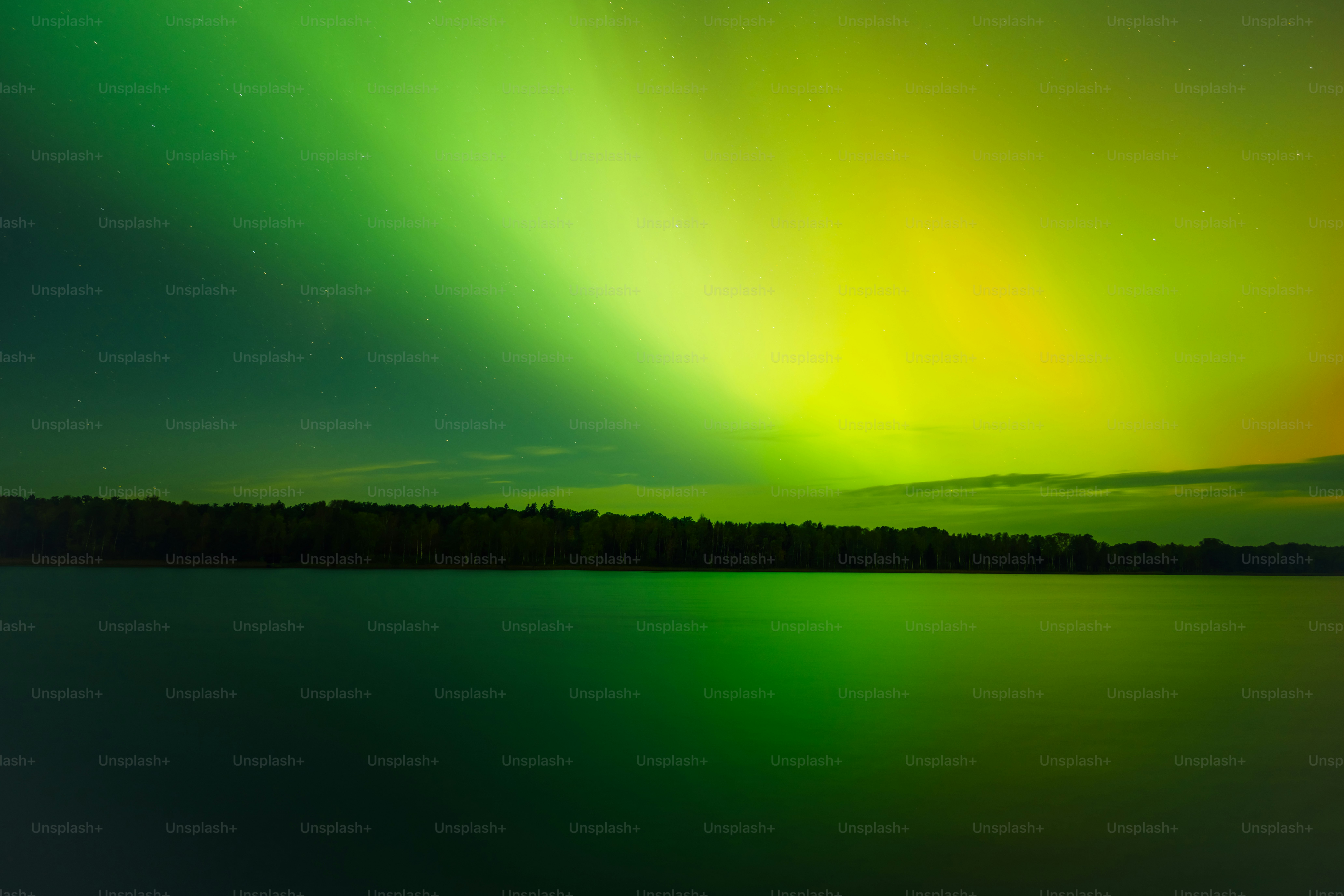 A green and red aurora bore over a body of water photo – Aurora ...