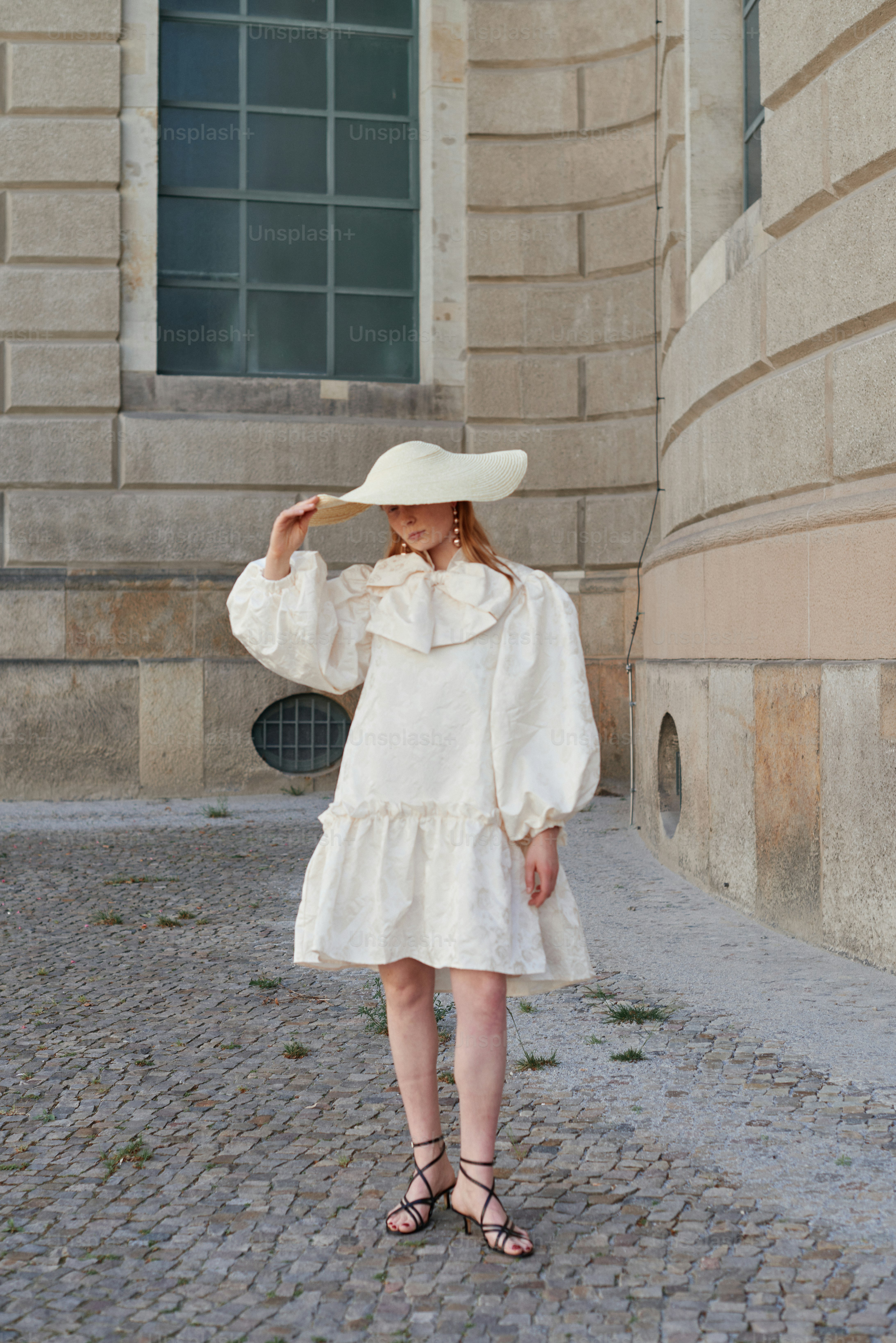 A woman wearing a large white hat on top of her head photo – Fashion ...