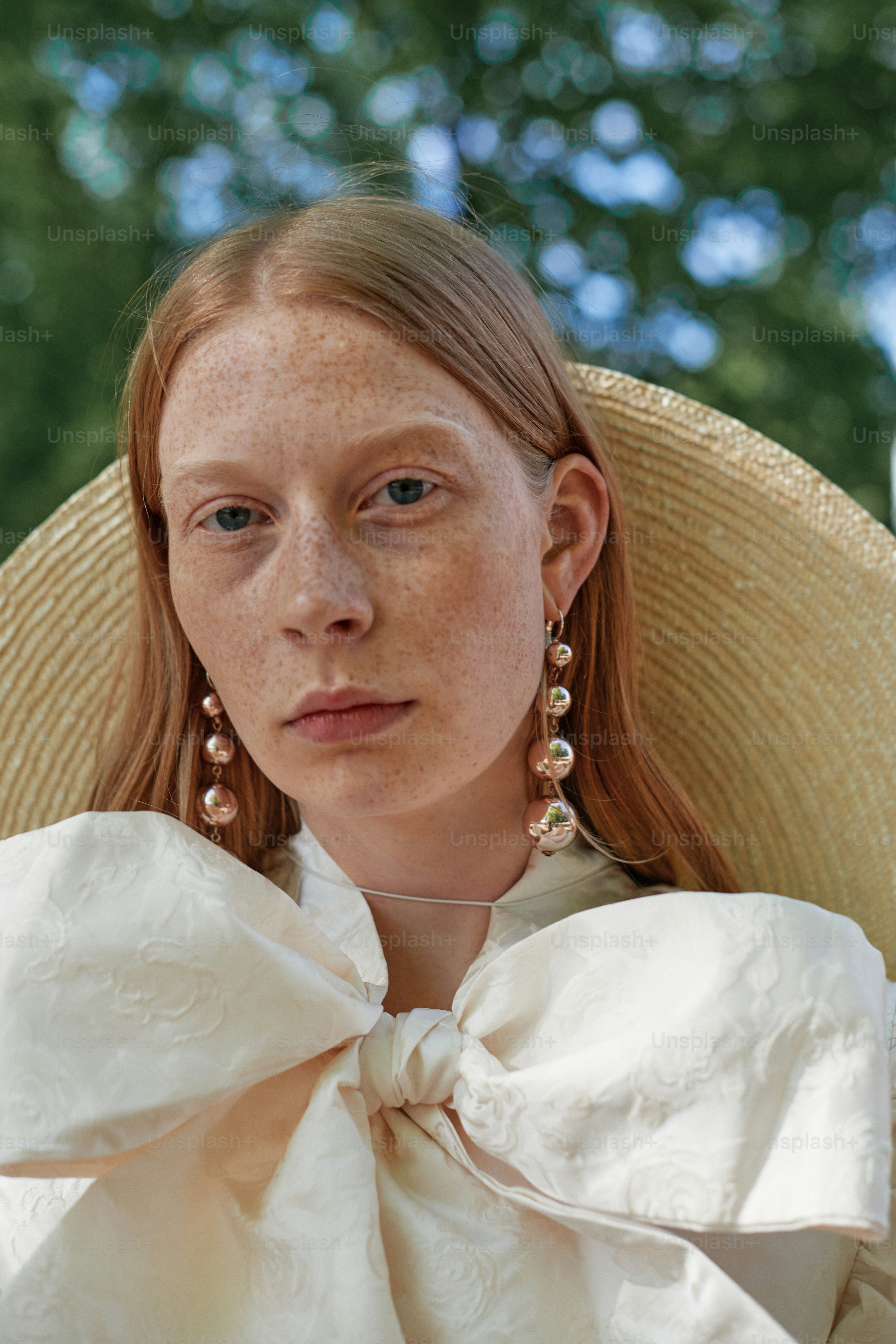 Uma mulher usando um chapéu grande com um laço em volta do pescoço foto ...