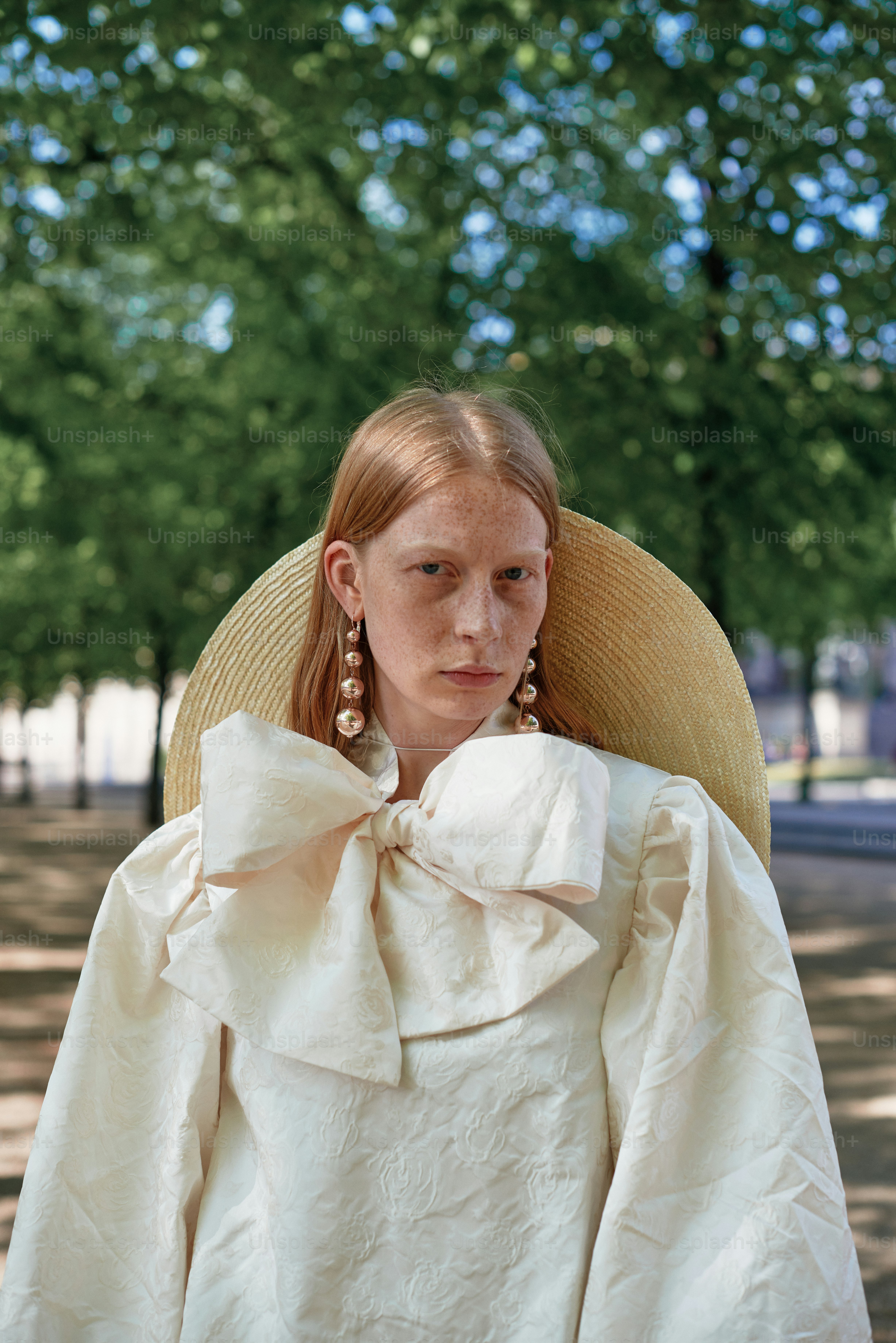 A woman wearing a large white hat on top of her head photo – Fashion ...
