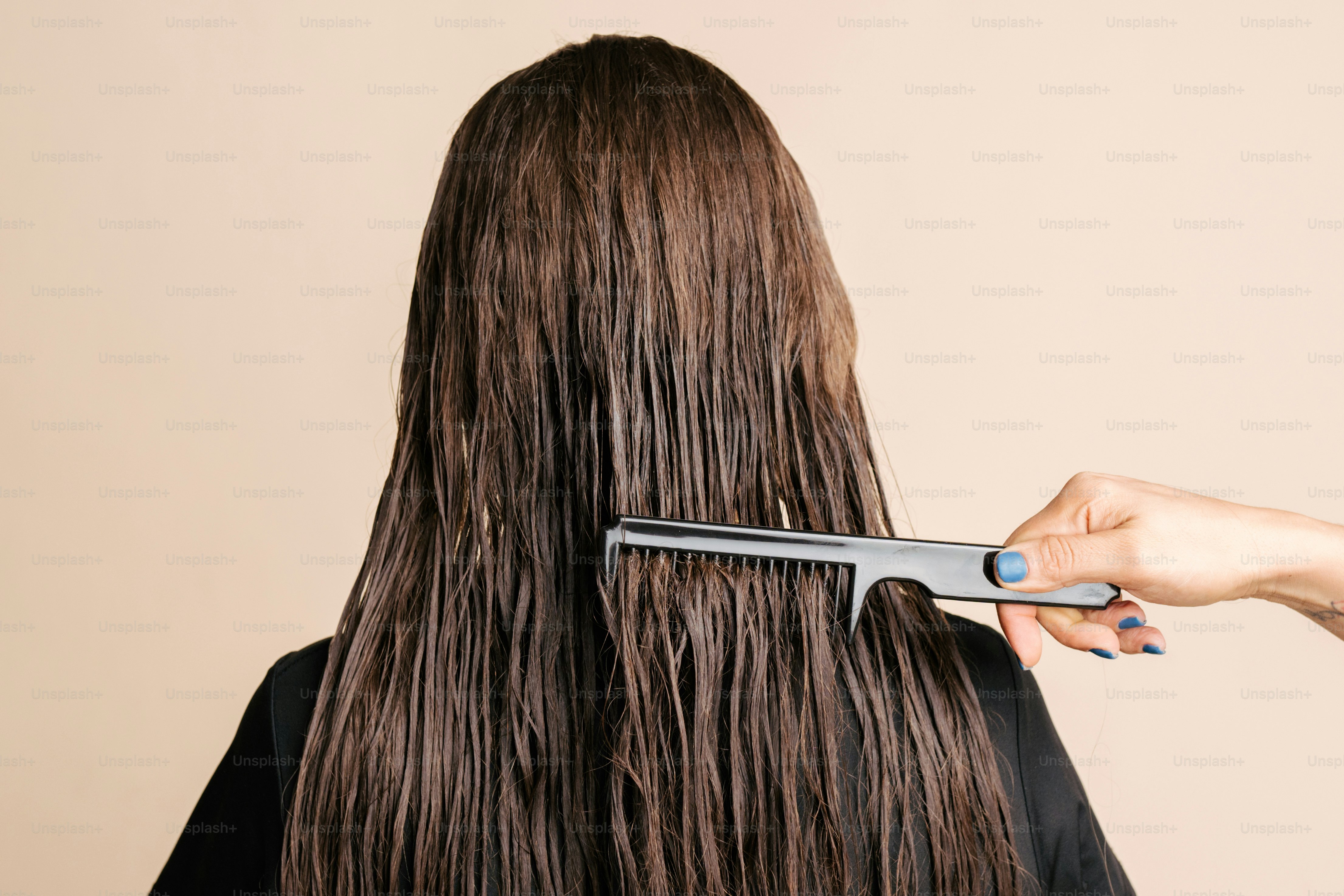 A woman is cutting her long hair with a scissor photo – Self care Image ...
