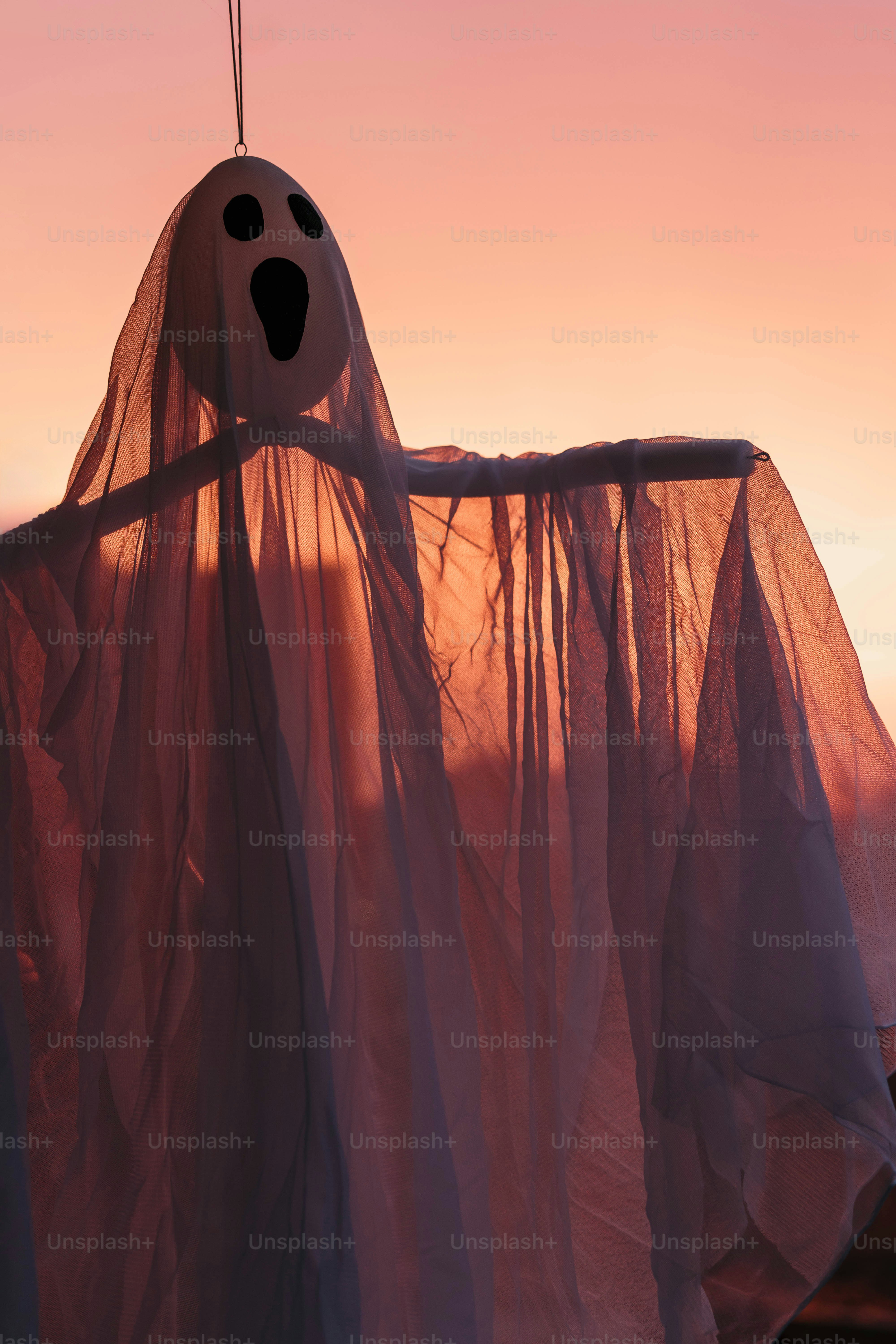 A ghost hanging from a hook on a pole photo – Halloween decorations ...