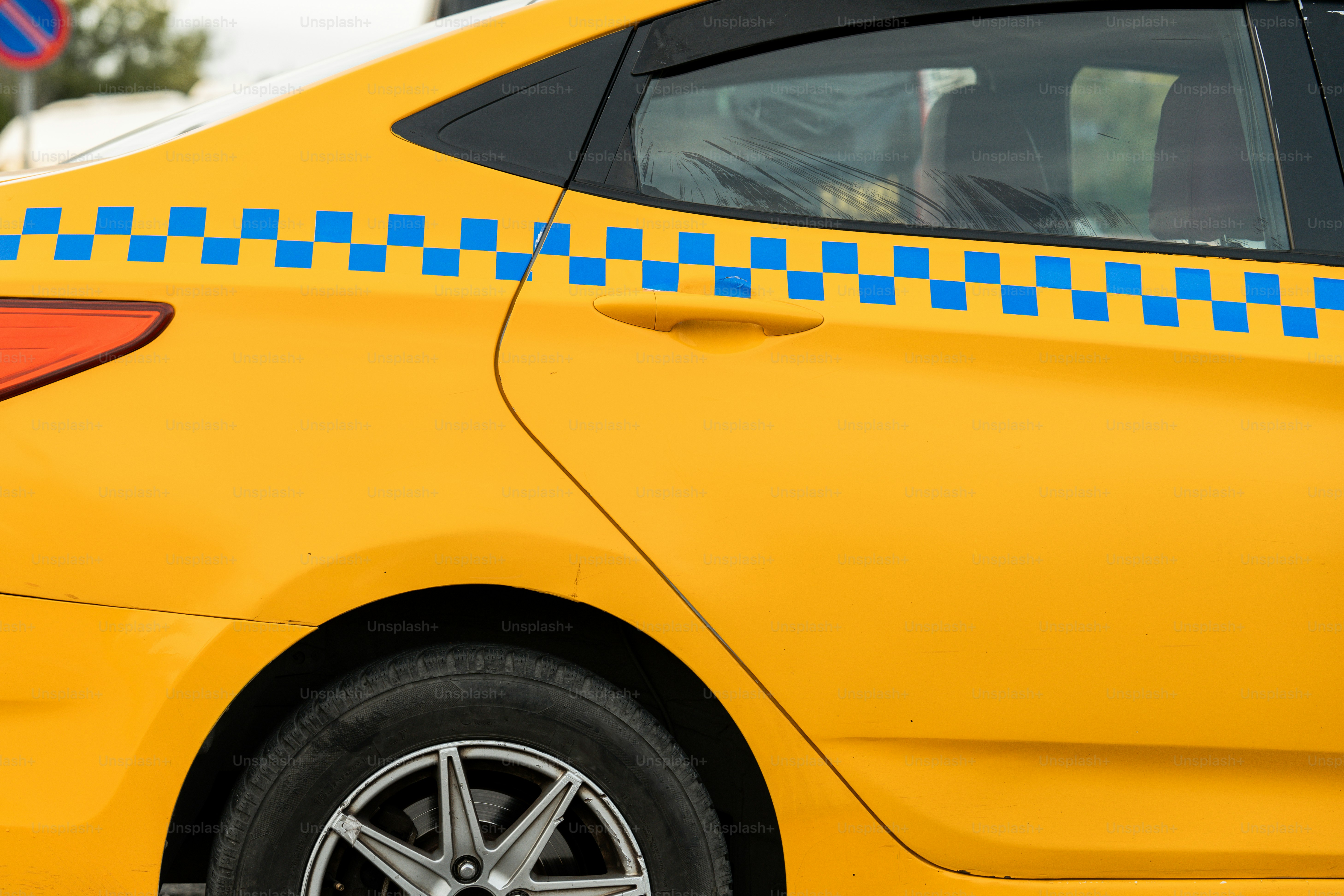 A close up of a yellow car with a blue checkered decal photo – Public ...