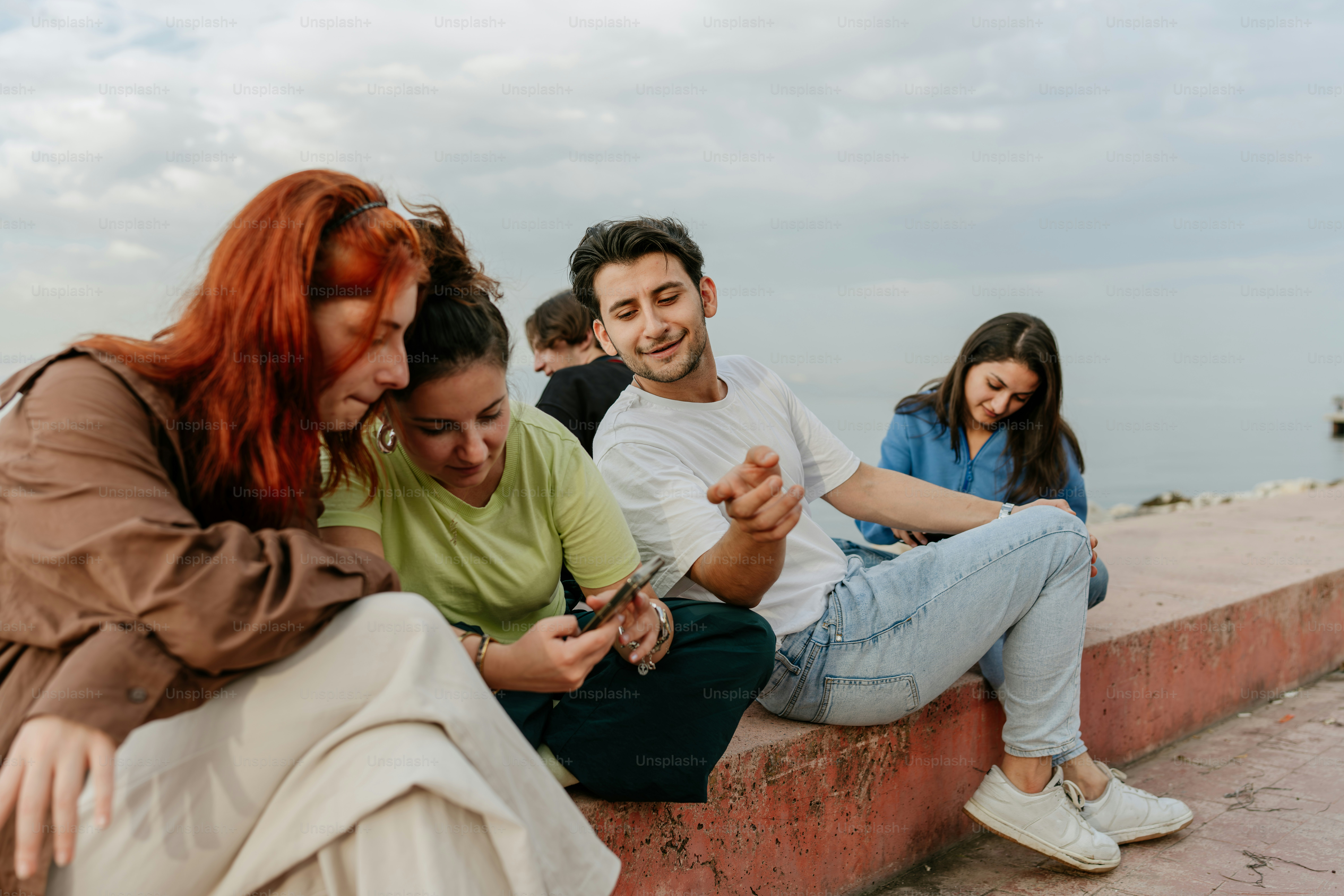 A group of people sitting next to each other photo – Friends Image on ...