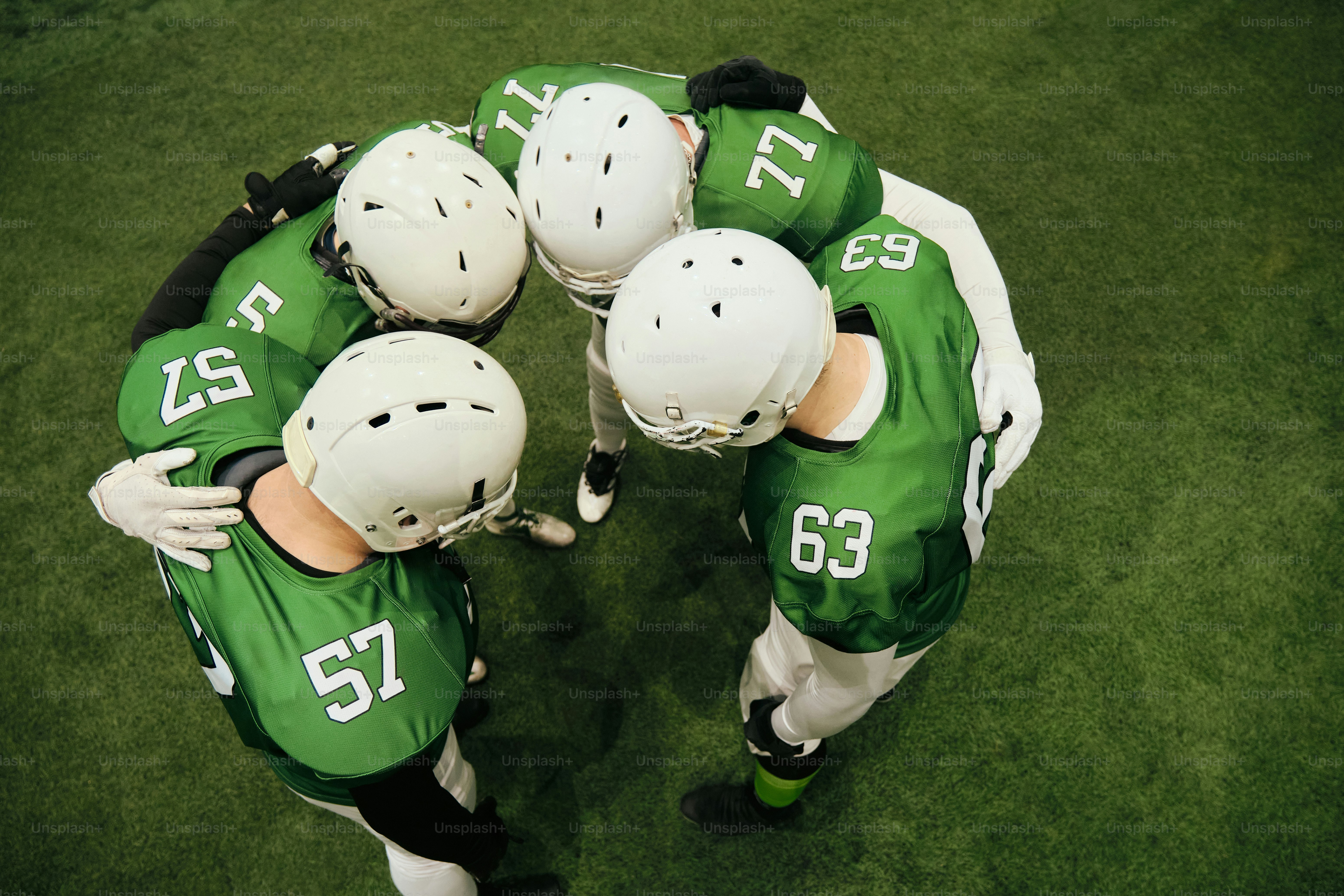 A group of football players huddle together in a huddle photo – Team ...