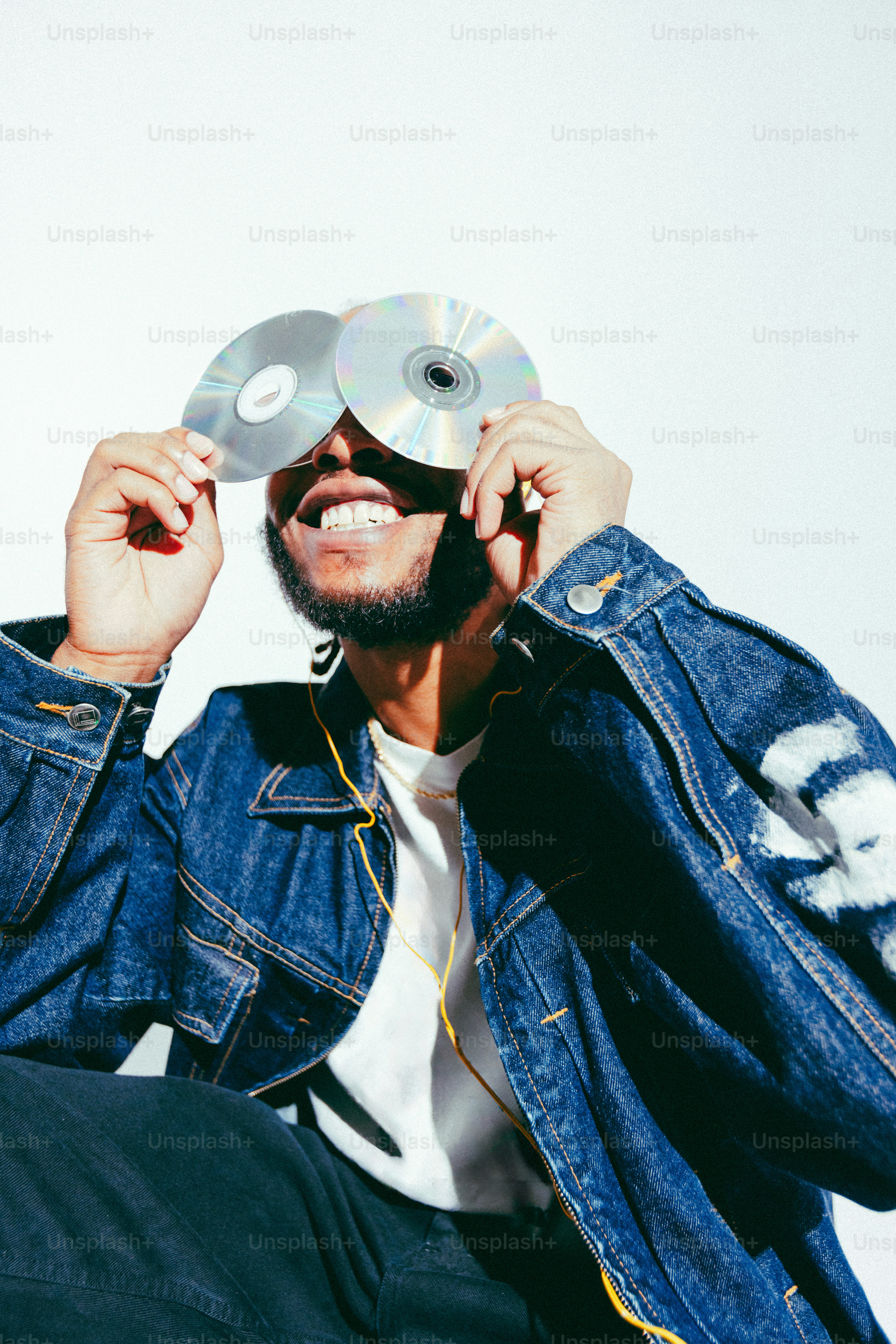 A man sitting on a chair holding a cd in front of his face photo – Cds ...