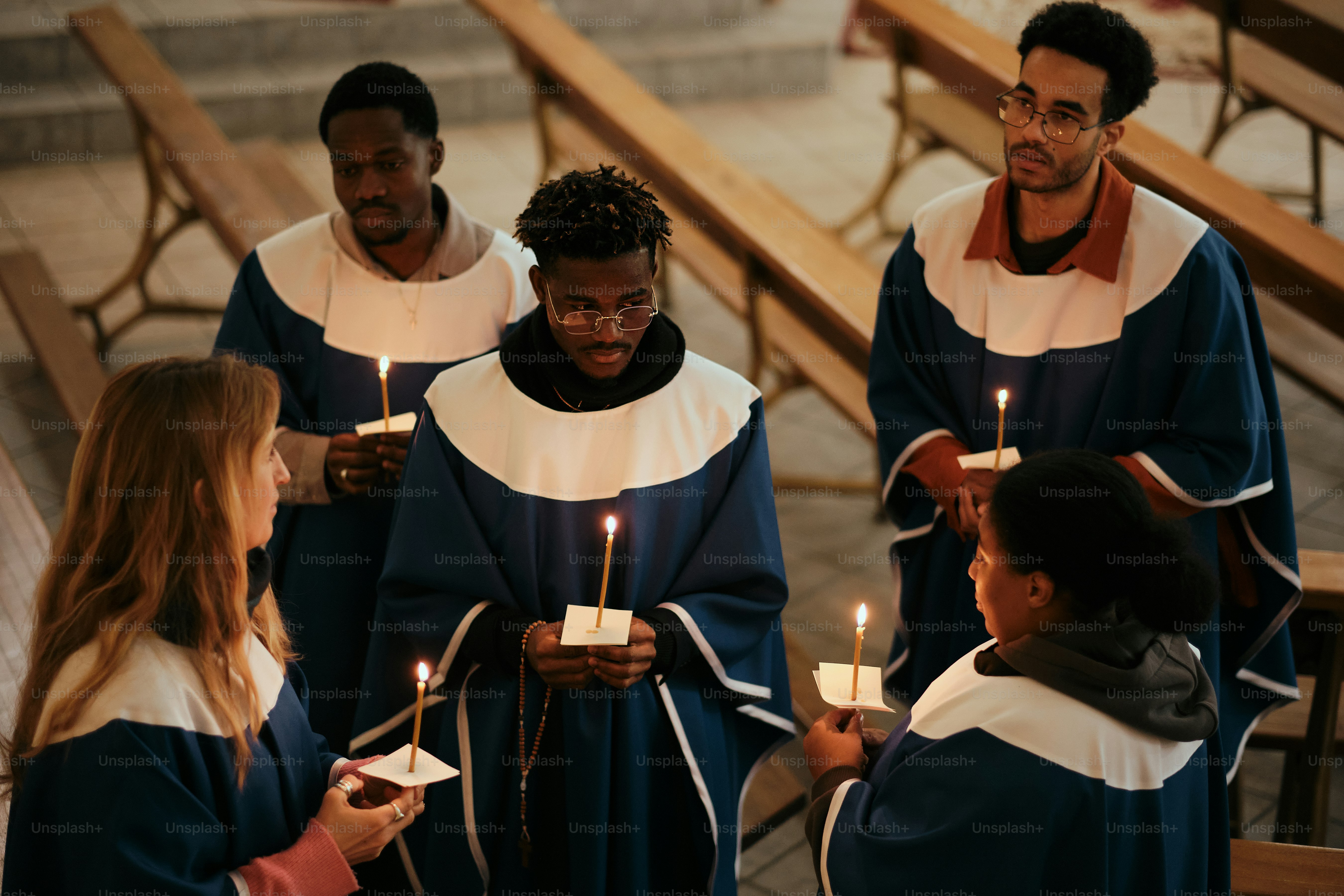A group of people standing around each other holding candles photo ...