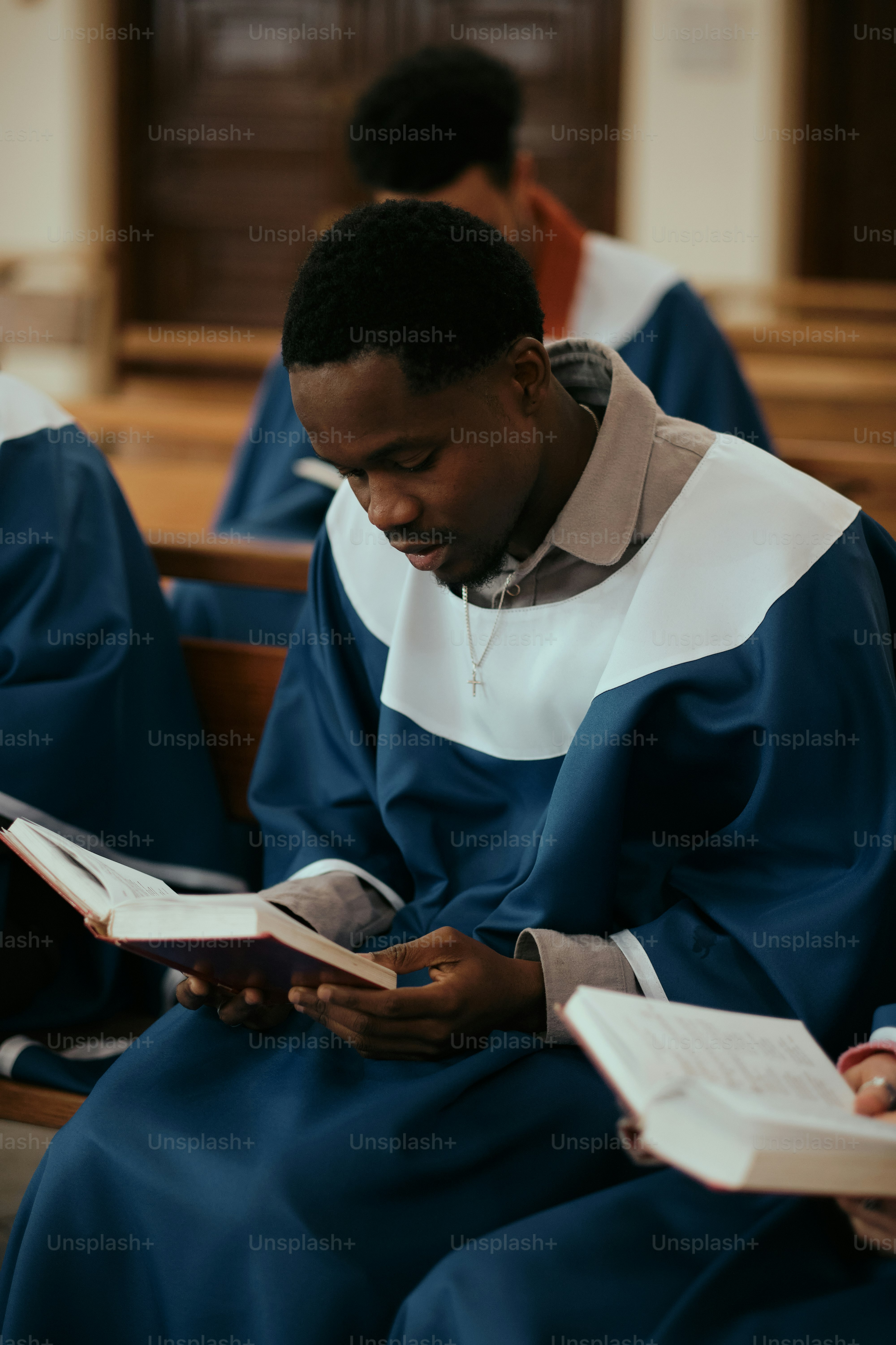 A group of people sitting in a church reading books photo – Church ...