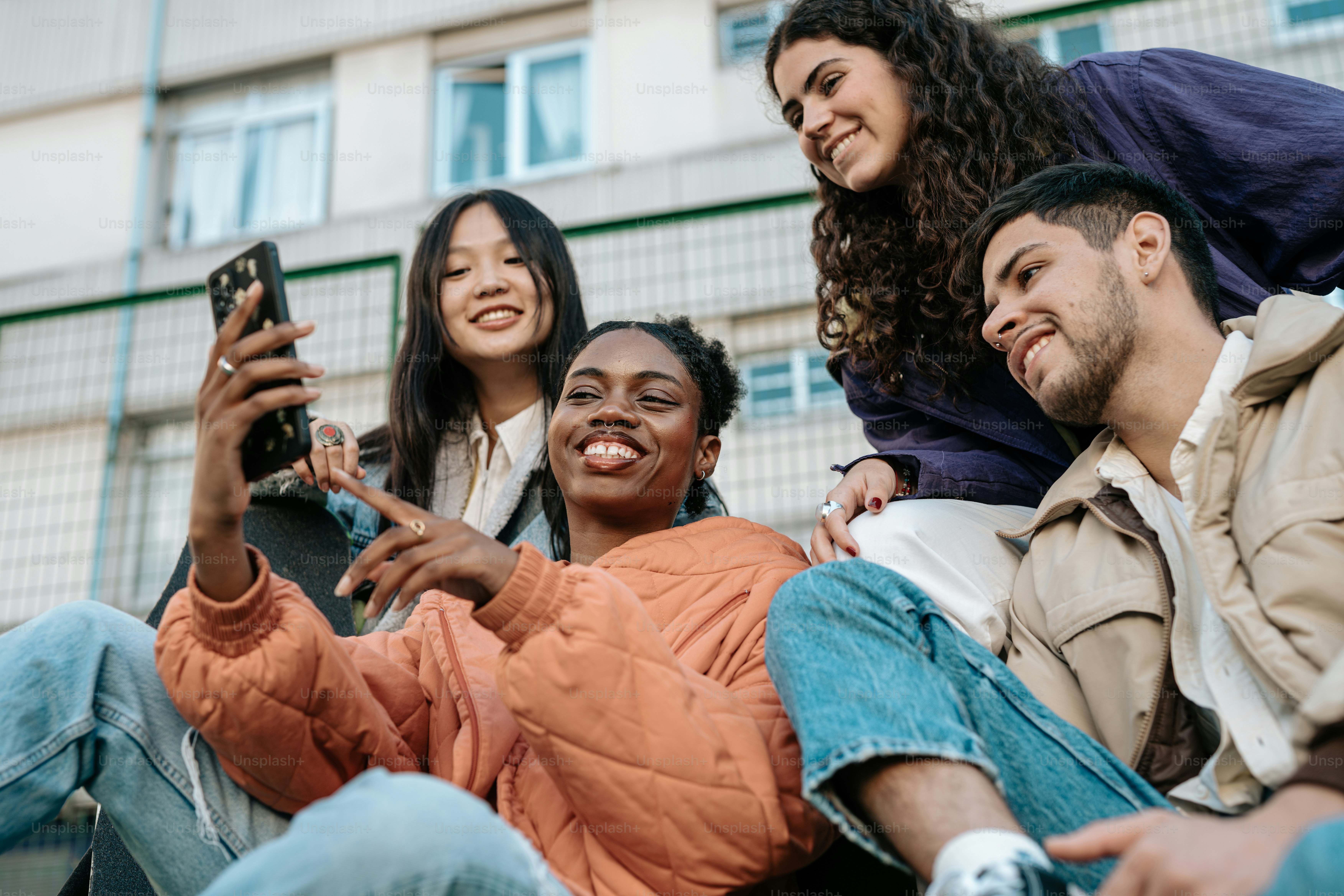 A group of people sitting next to each other photo – Friendships Image ...