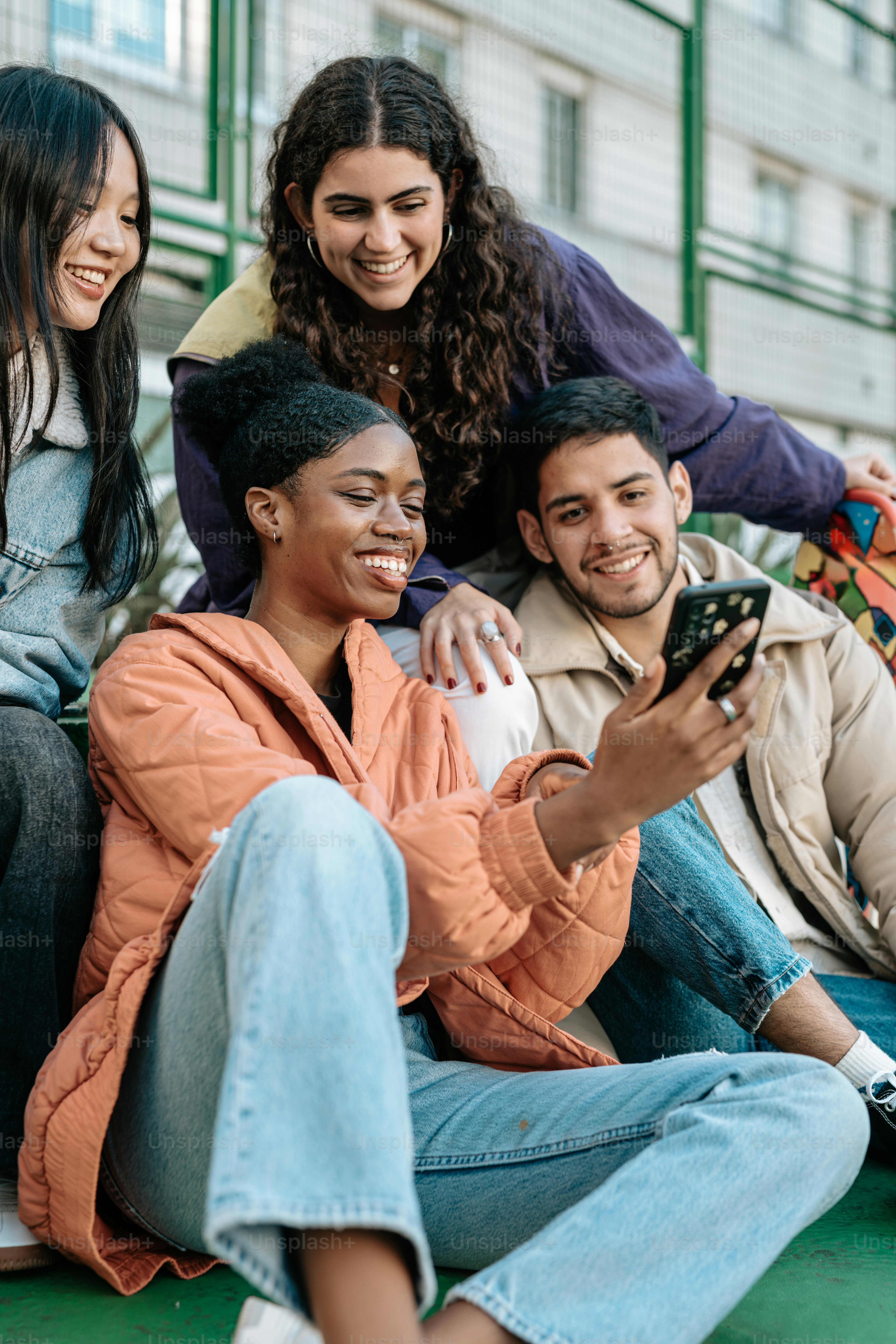 A group of people sitting next to each other photo – Friendships Image ...