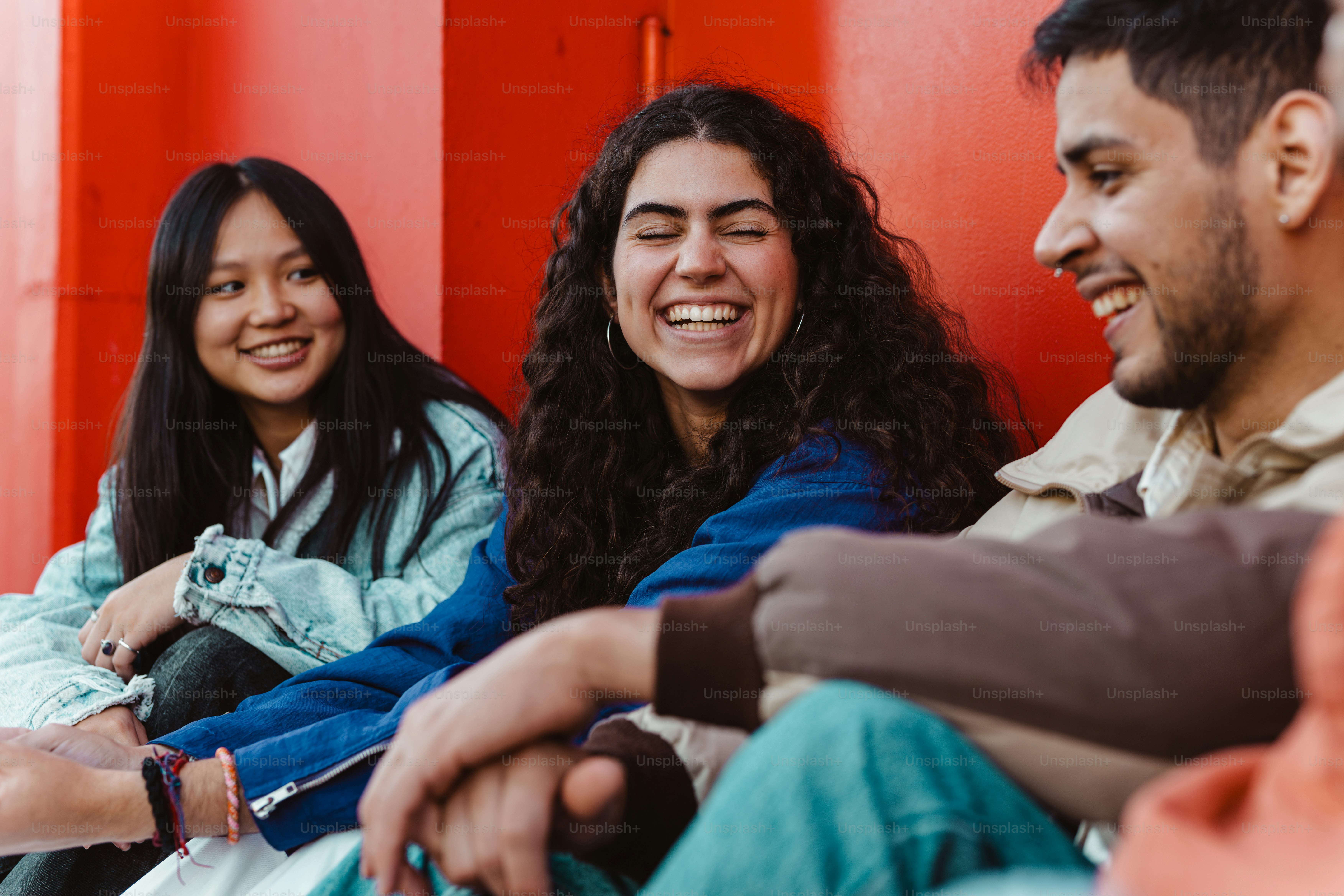 A group of people sitting next to each other photo – Friendships Image ...
