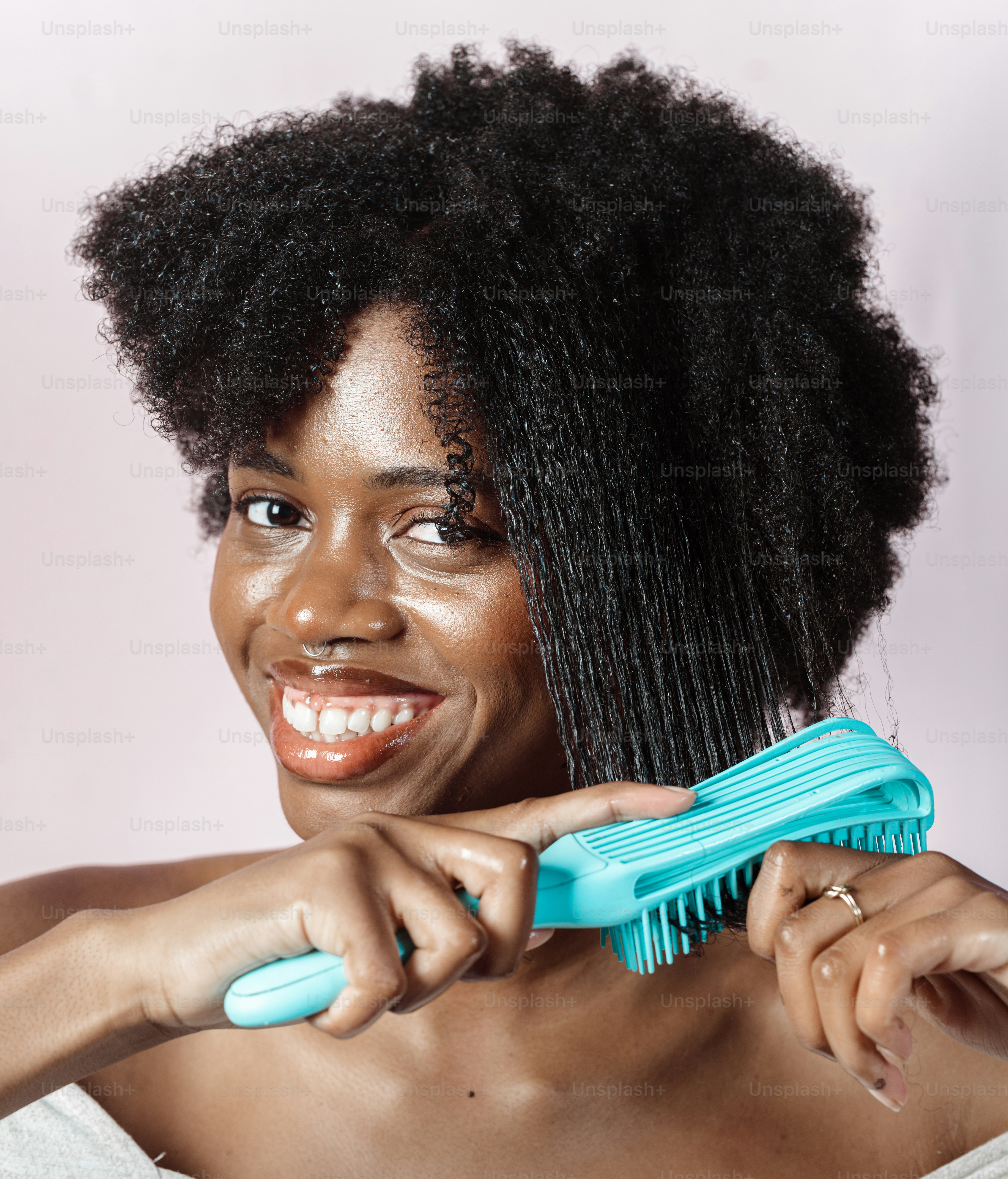A woman brushing her hair with a blue brush photo – Natural beauty ...
