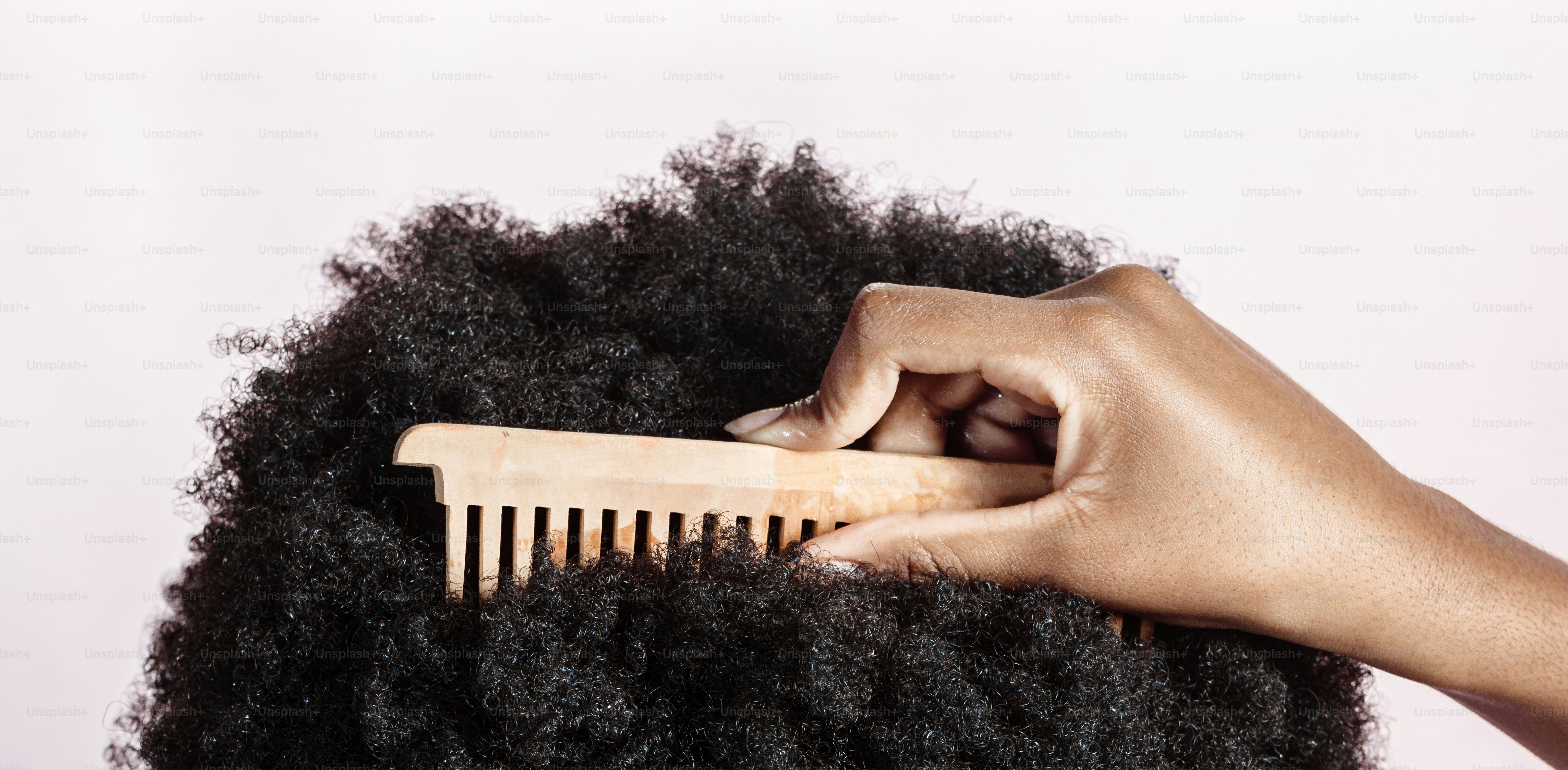 A close up of a person combing their hair photo – Self care Image on ...