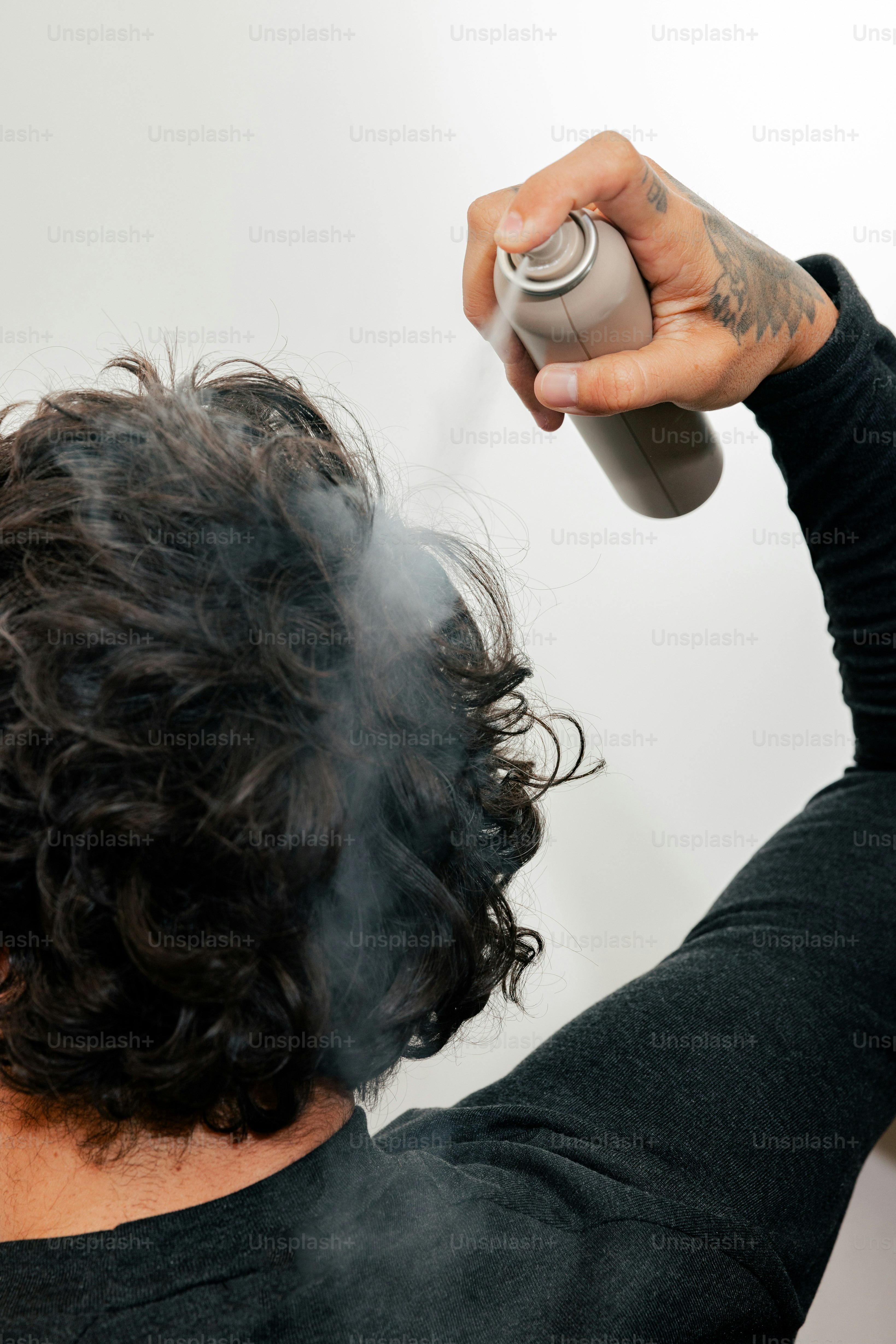 A woman is spraying her hair with a hair dryer photo – Hair spray Image ...