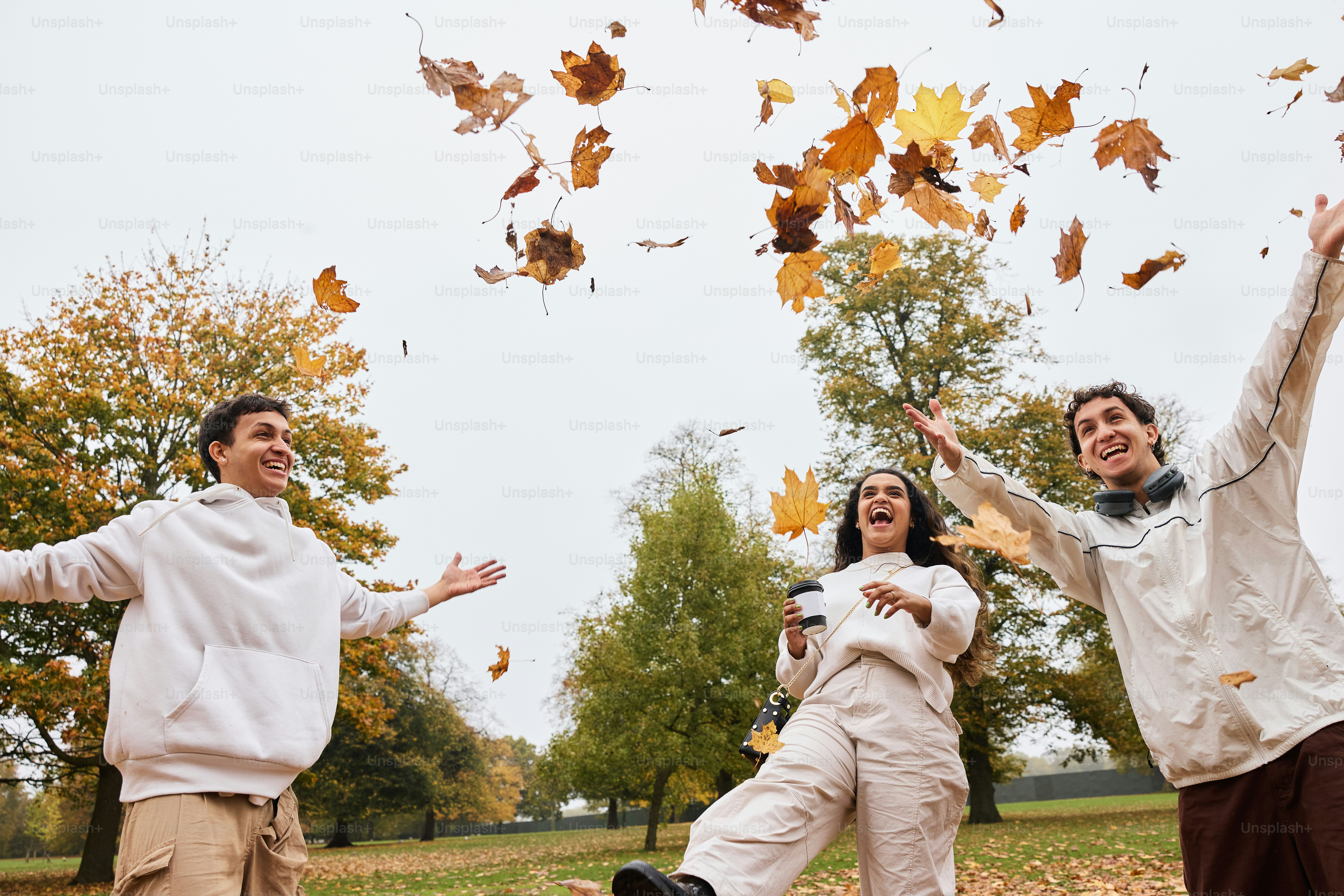A group of people throwing leaves in the air photo – Friends Image on ...