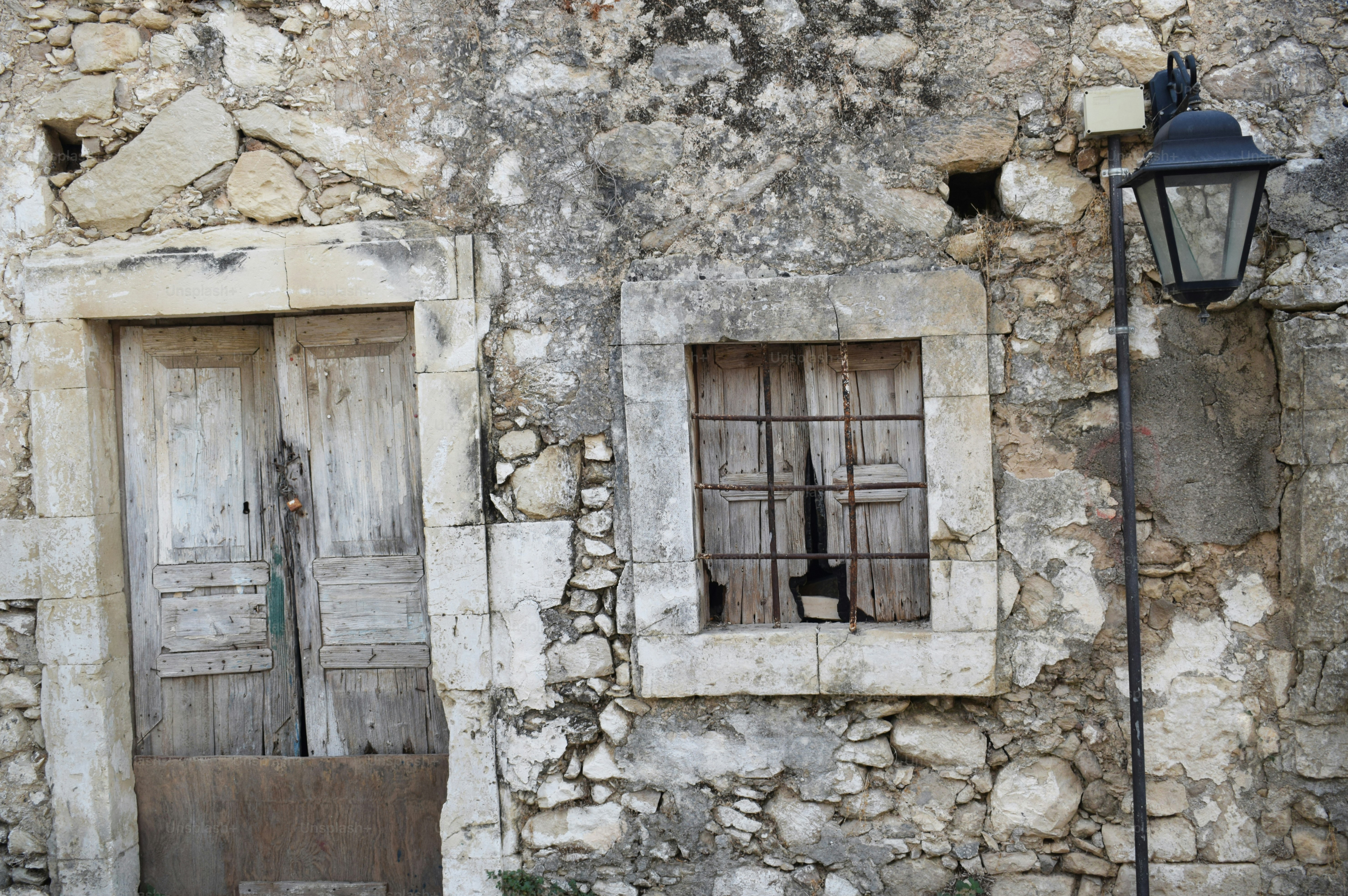 An old stone building with two windows and a door photo – Urban decay ...