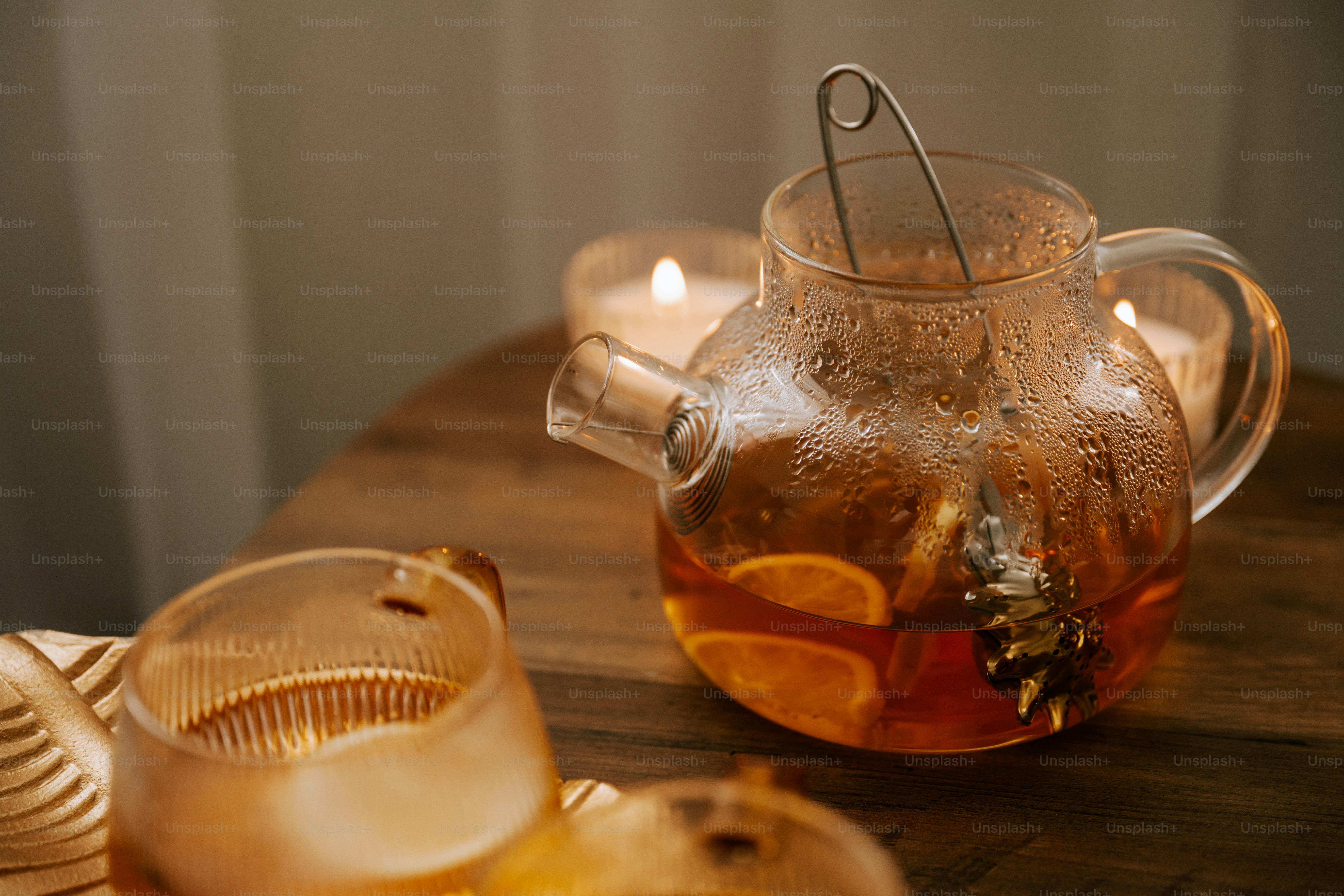 A glass tea pot filled with tea sits on a table photo – Fresh tea Image ...