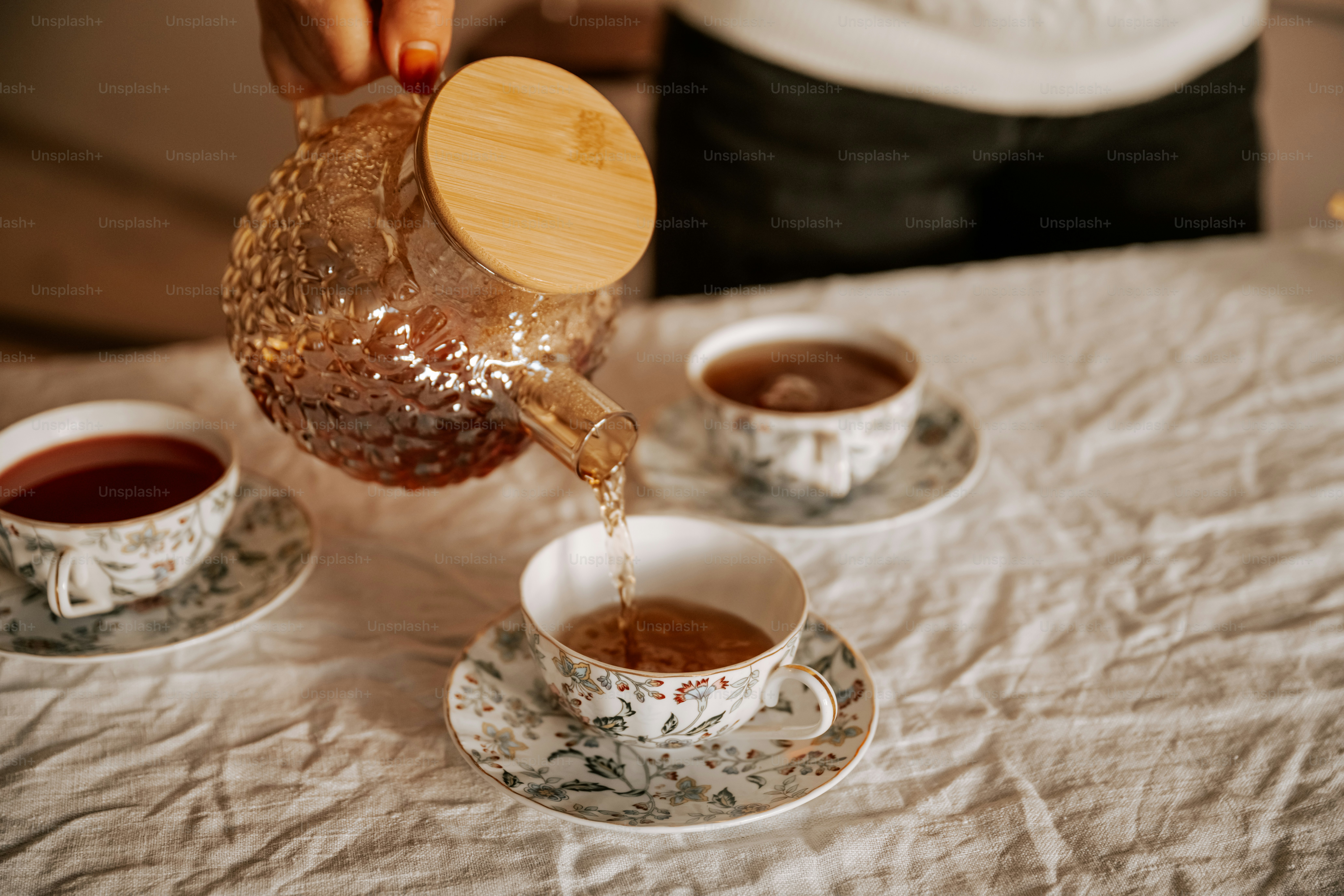 A person pouring tea into cups on a table photo – Tea Image on Unsplash