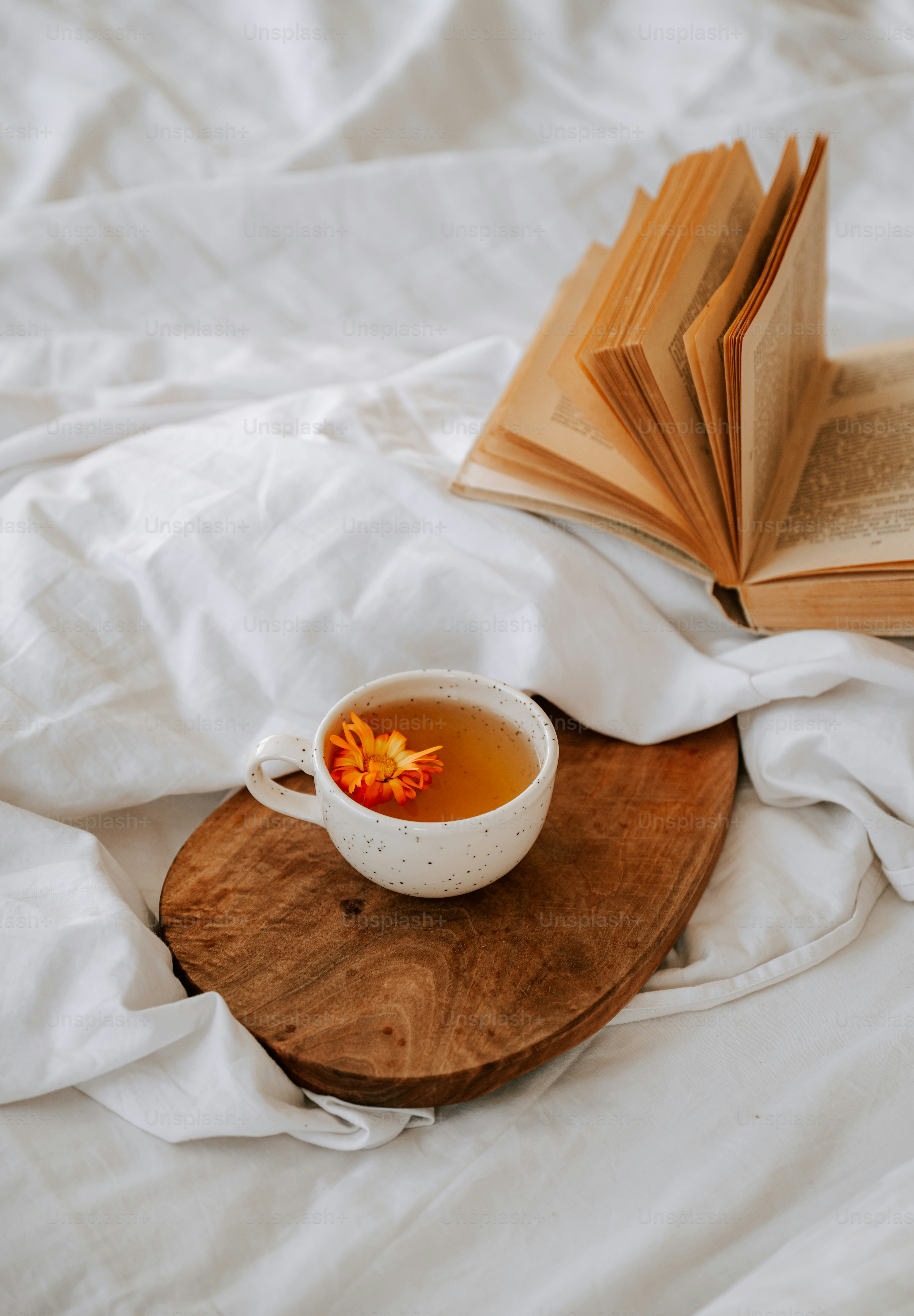 An open book and a cup of tea on a bed photo – Tea ritual Image on Unsplash