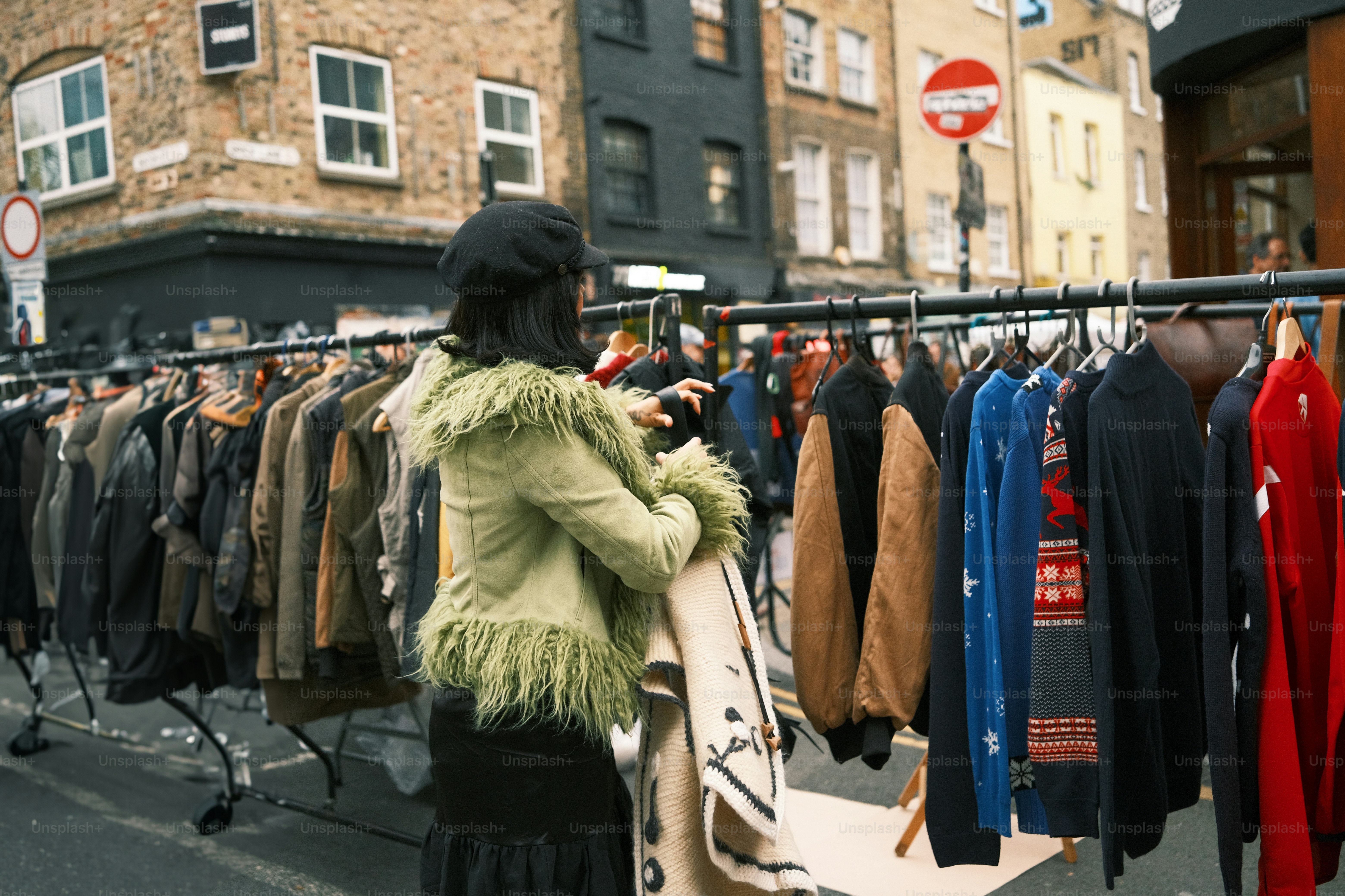 A woman standing in front of a rack of clothes photo – Thrifting Image ...