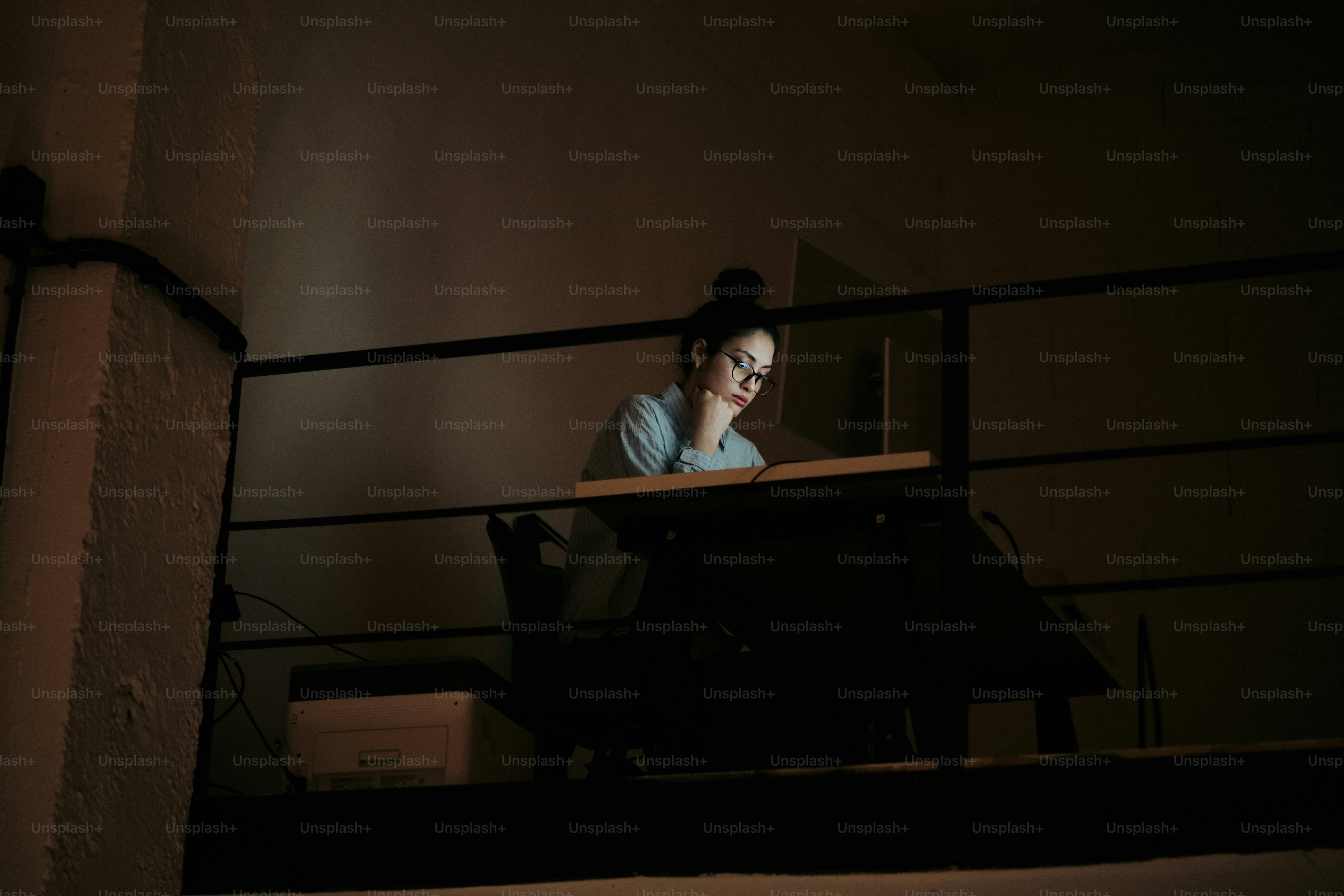 A woman sitting at a table in the dark photo – Woman Image on Unsplash