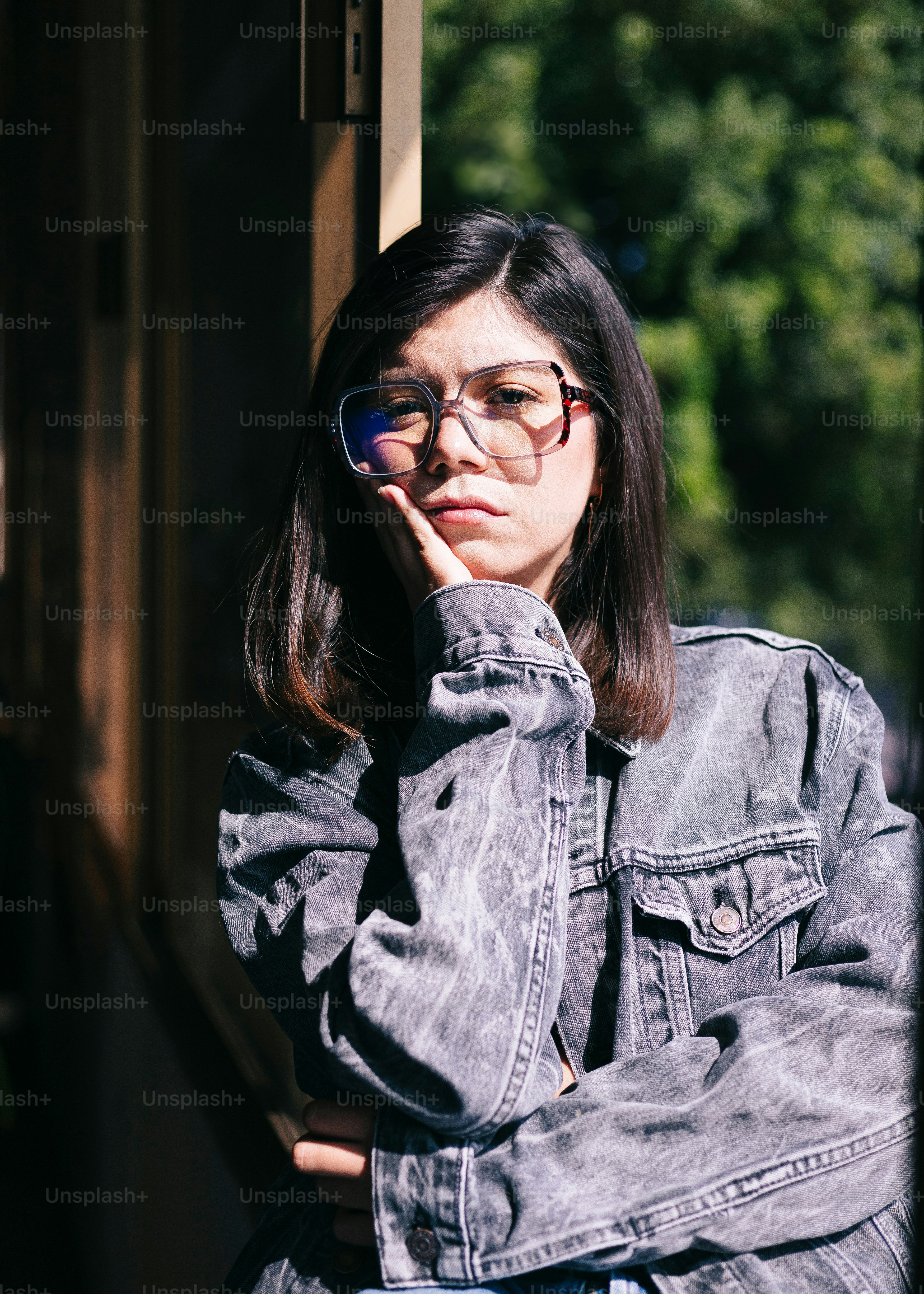 A woman in a denim jacket leaning against a wall photo – Profile Image ...