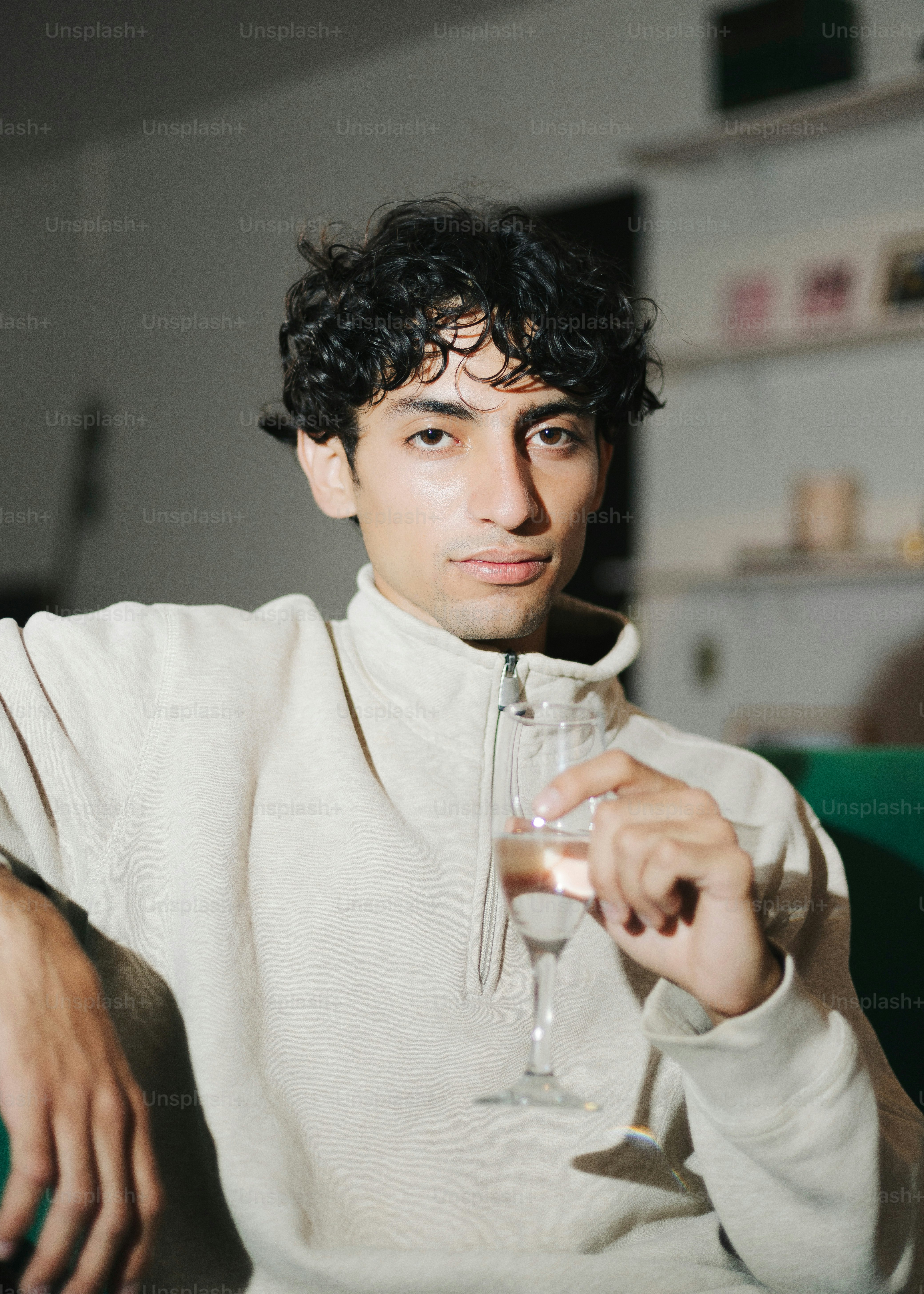 Un hombre sentado en un sofá sosteniendo una copa de vino foto – Imagen ...
