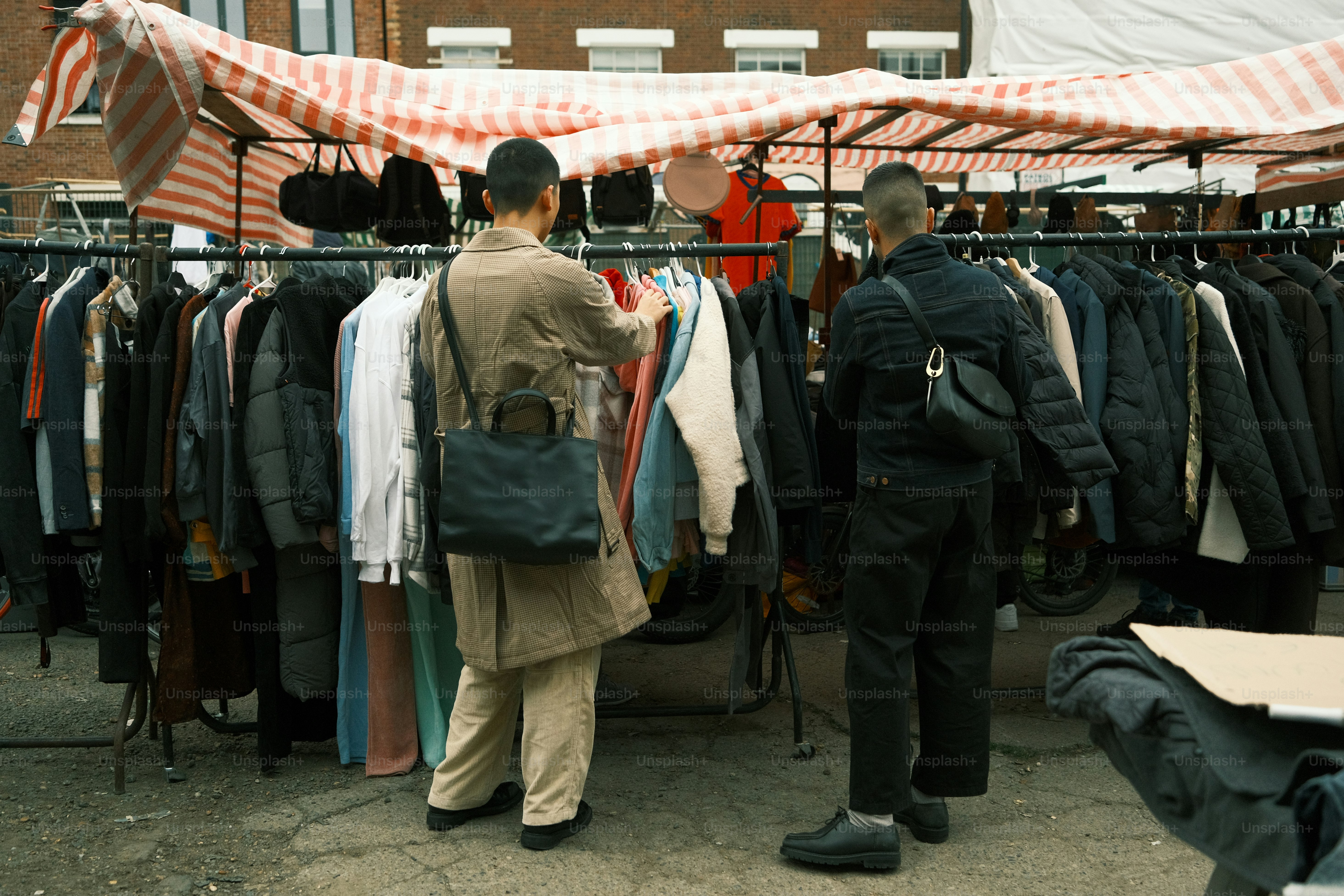 A man standing in front of a rack of clothes photo – Thrifting Image on ...
