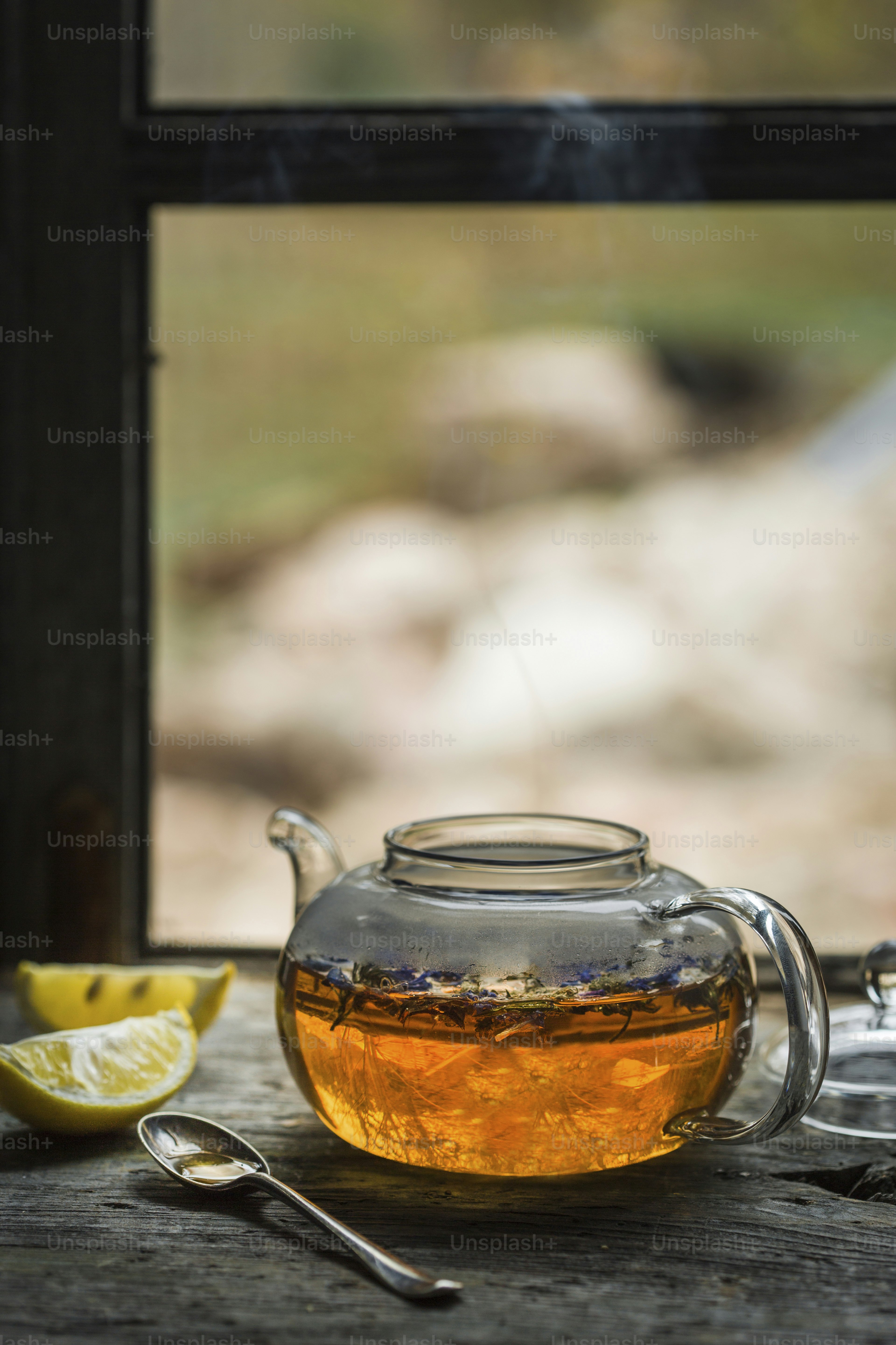 A glass tea pot filled with tea next to a lemon slice photo – Tea Image ...