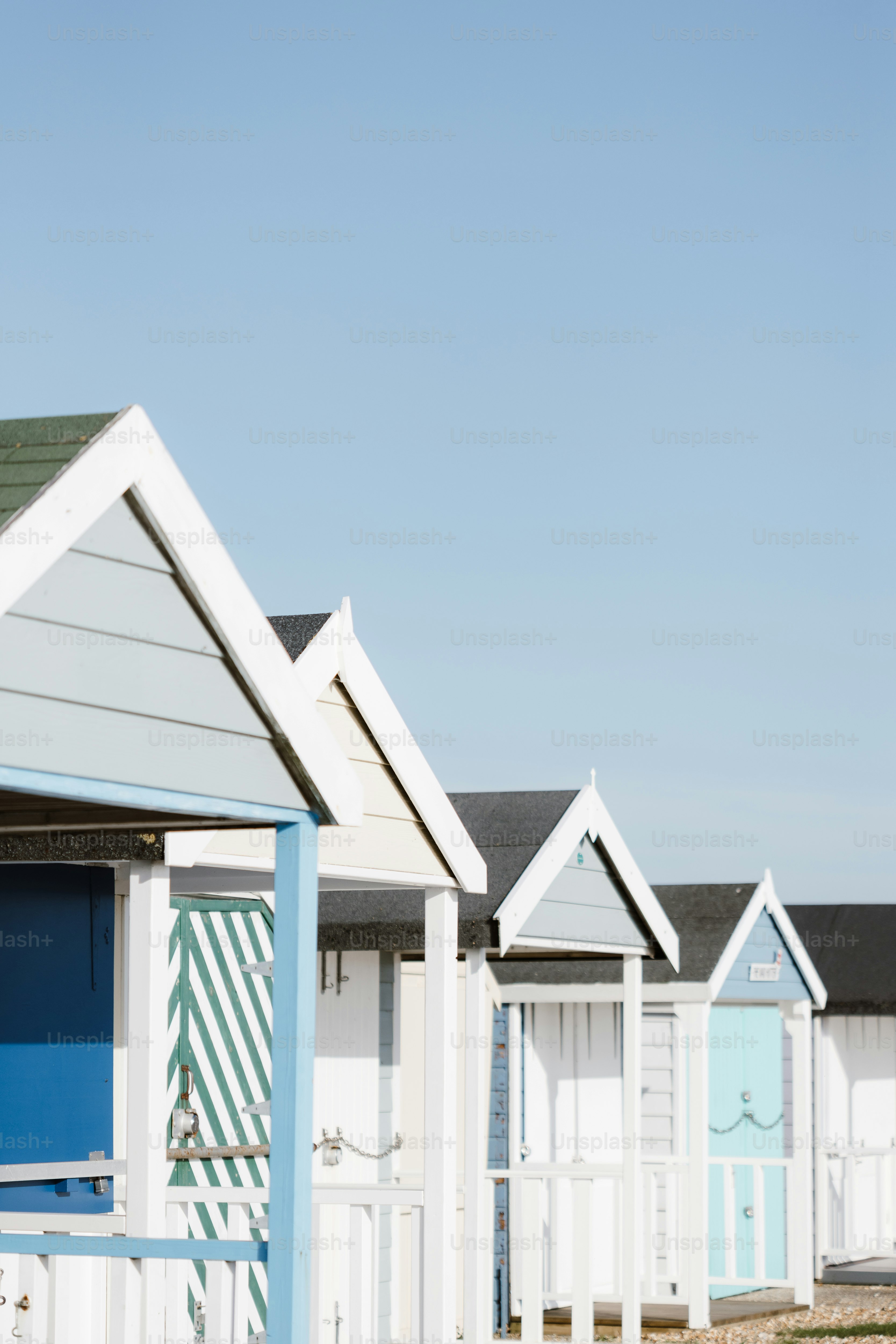 A row of beach huts sitting next to each other photo – Beach Image on ...