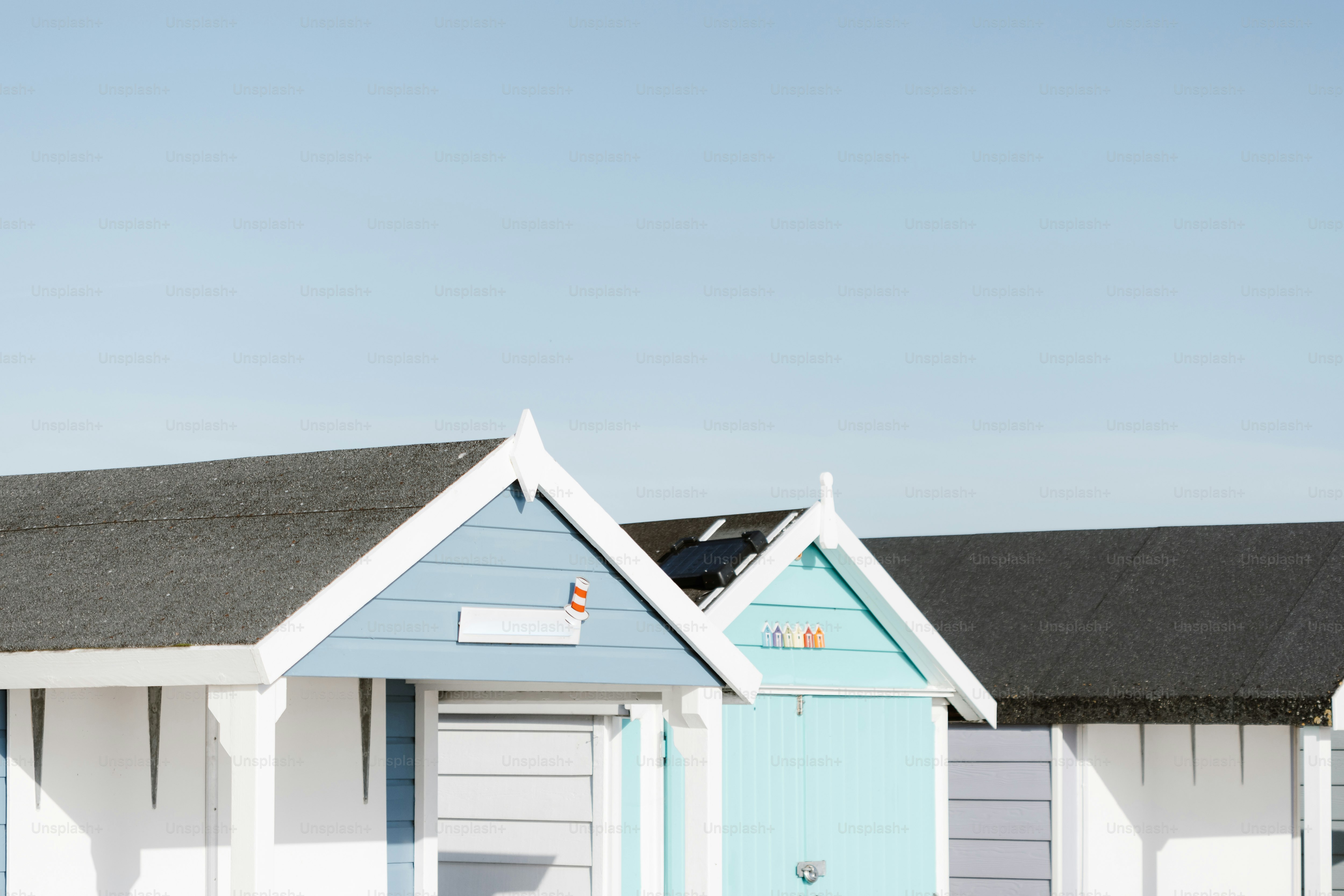 A row of beach huts sitting next to each other photo – Beach Image on ...