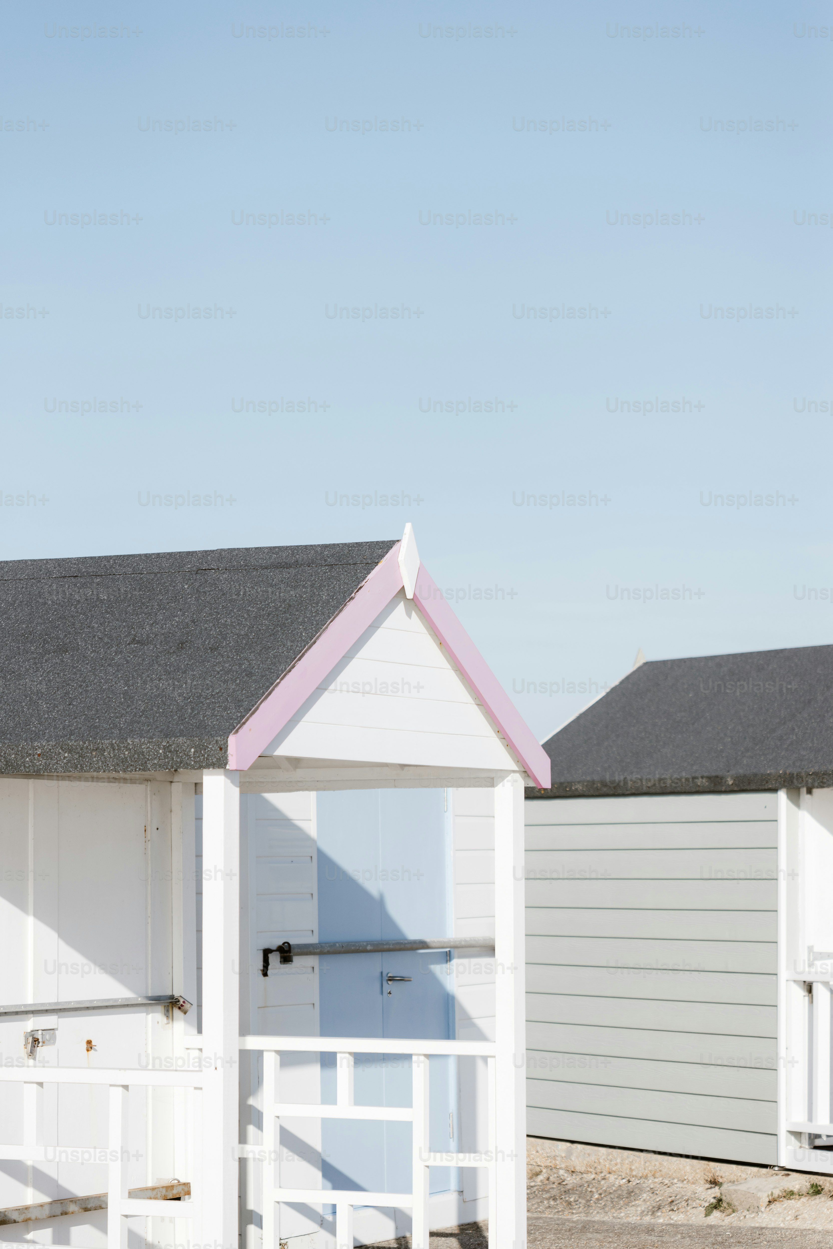 A row of white beach huts sitting next to each other photo – Beach ...