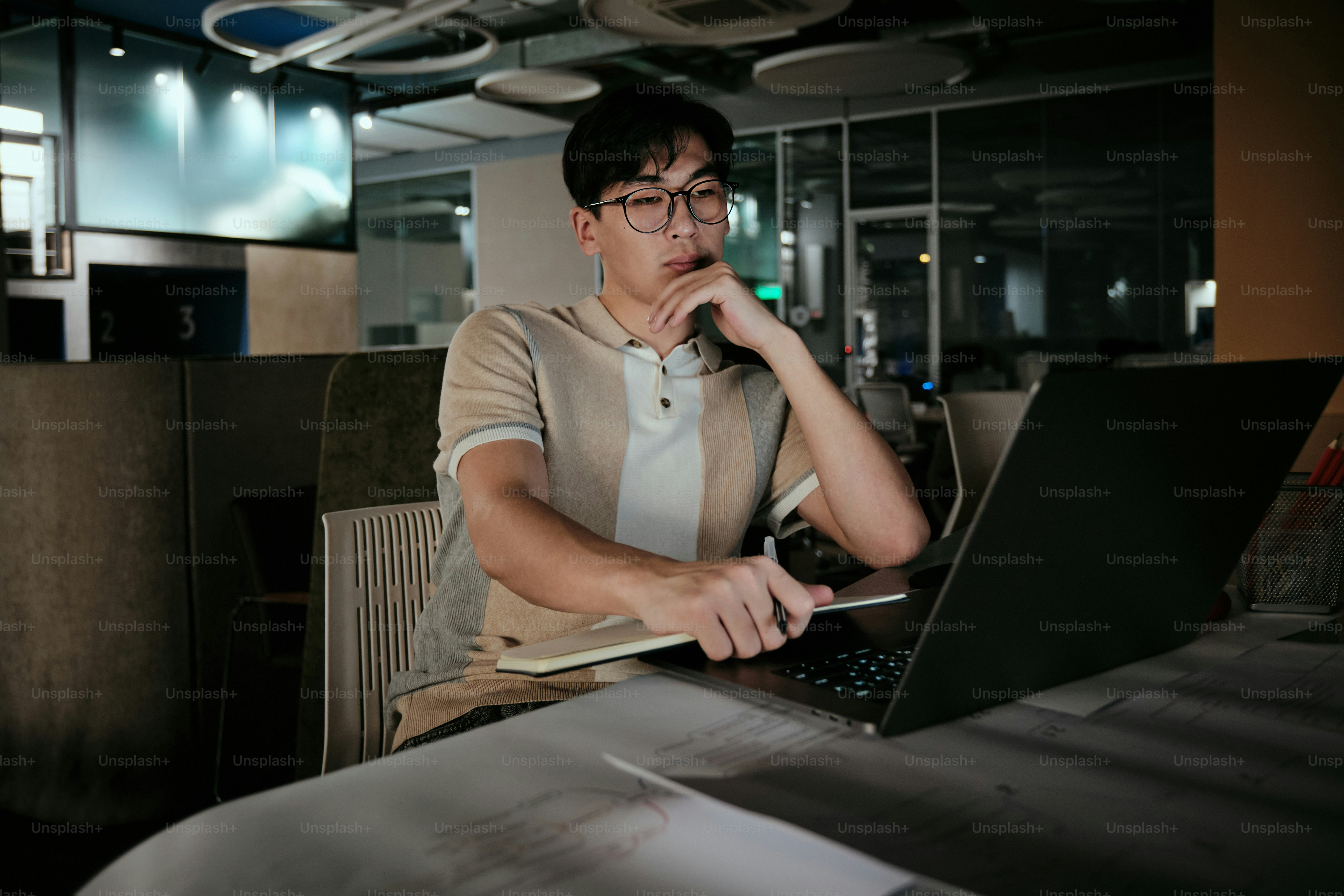 A man sitting in a chair using a laptop computer photo – Office Image ...