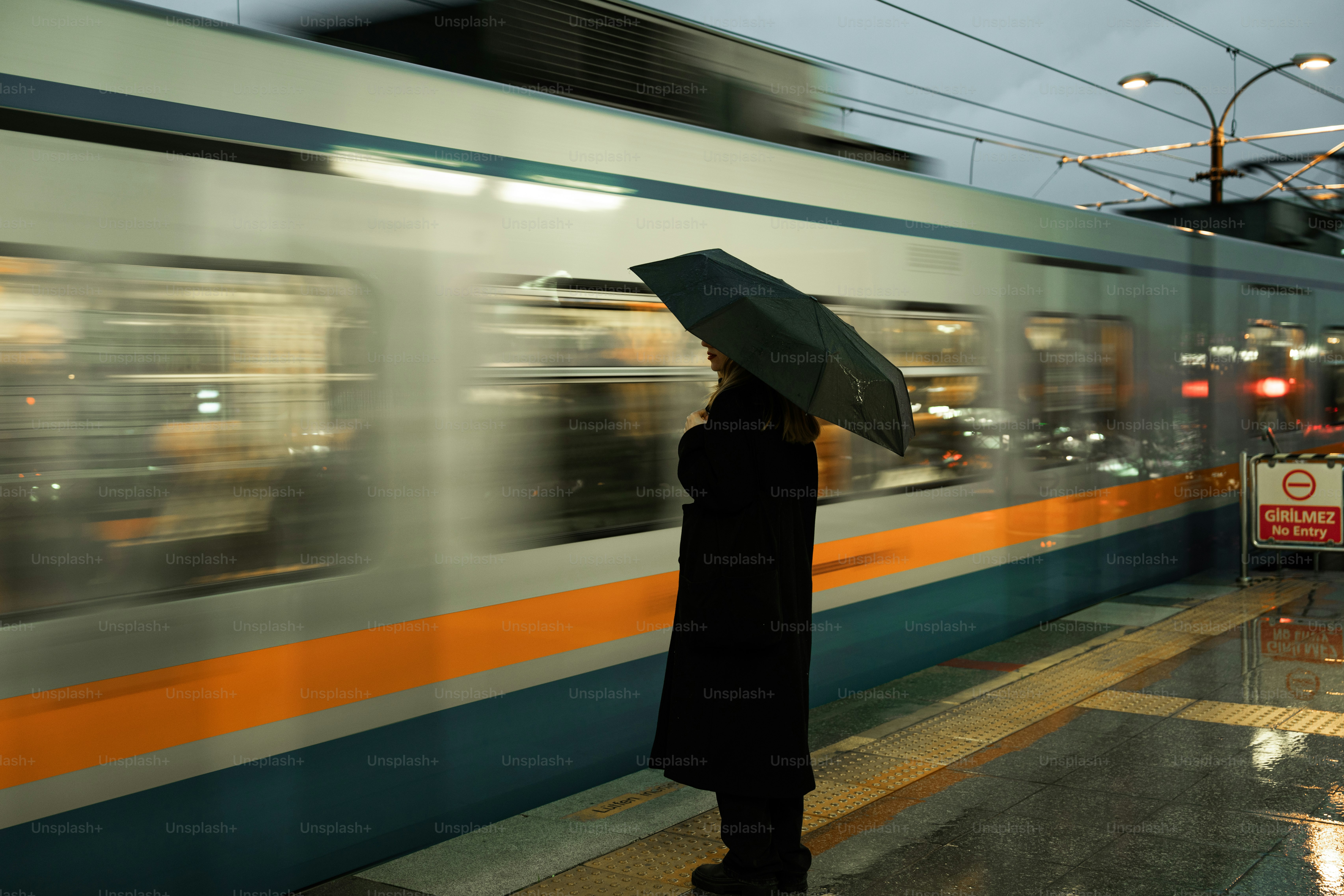 A person with an umbrella waiting for a train photo – Urban solitude Image on Unsplash
