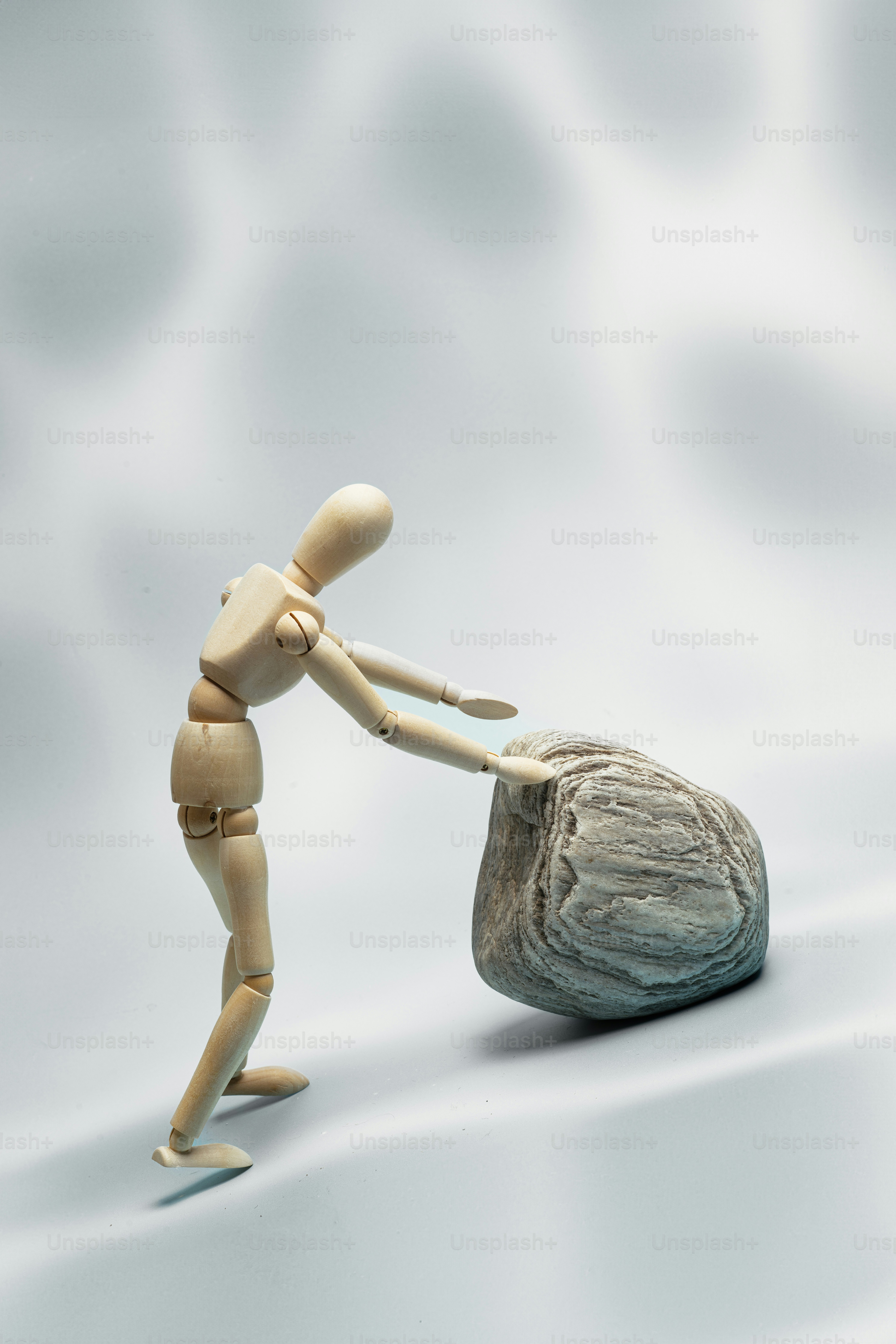 A wooden man pushing a rock with his hands photo – Energy Image on Unsplash