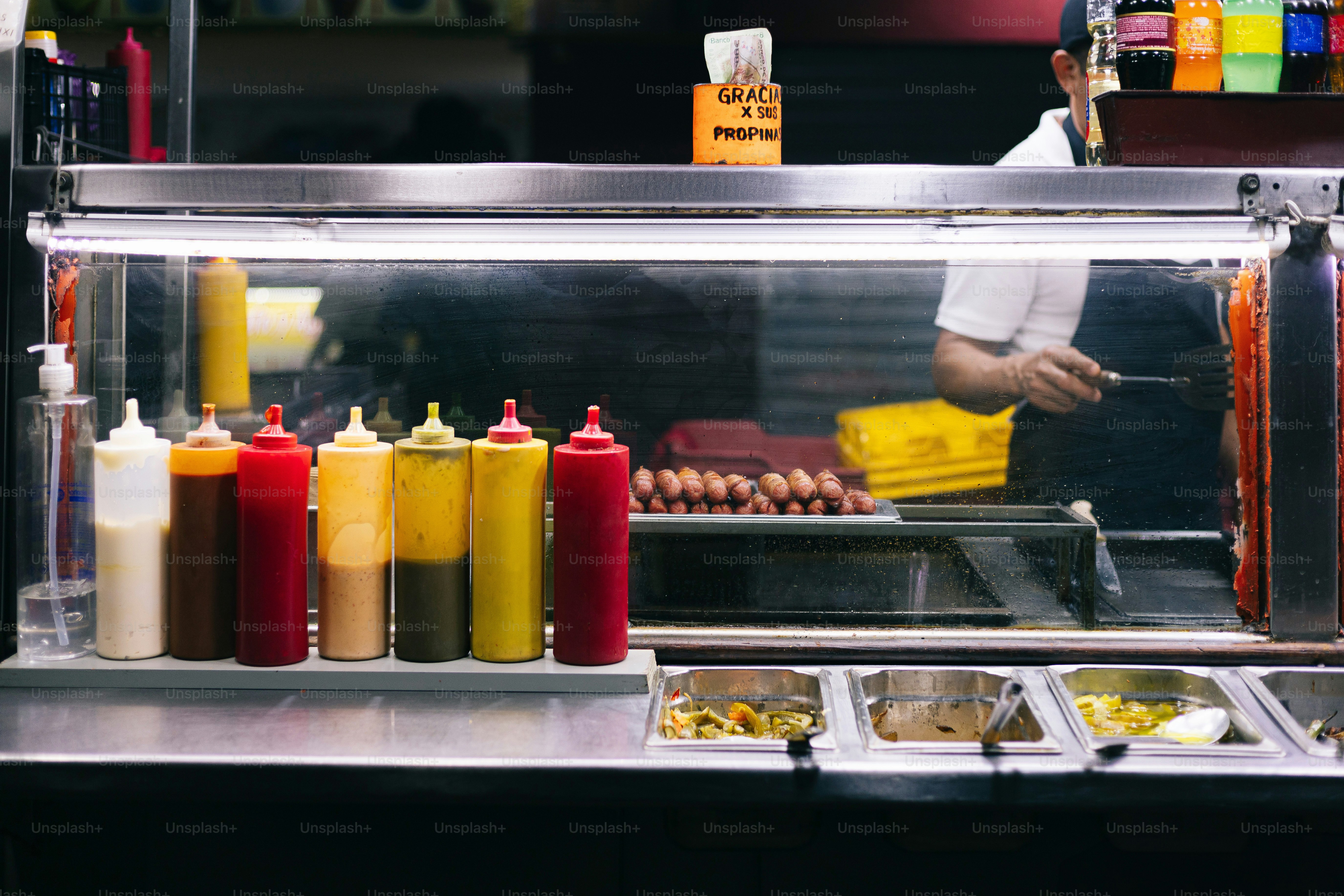 A person standing behind a counter in a restaurant photo – Food truck ...