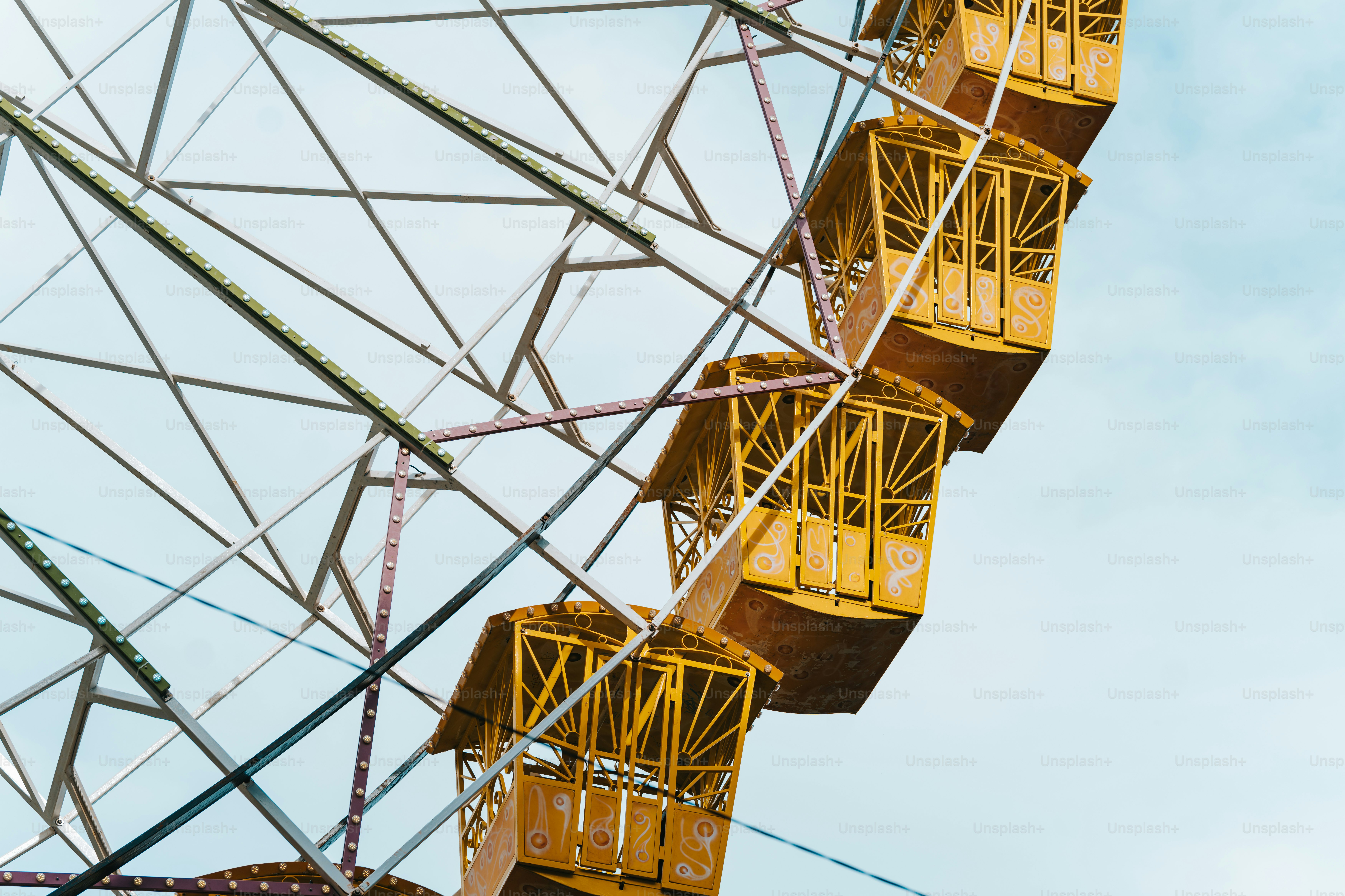 A yellow ferris wheel against a blue sky photo – Amusement park Image ...