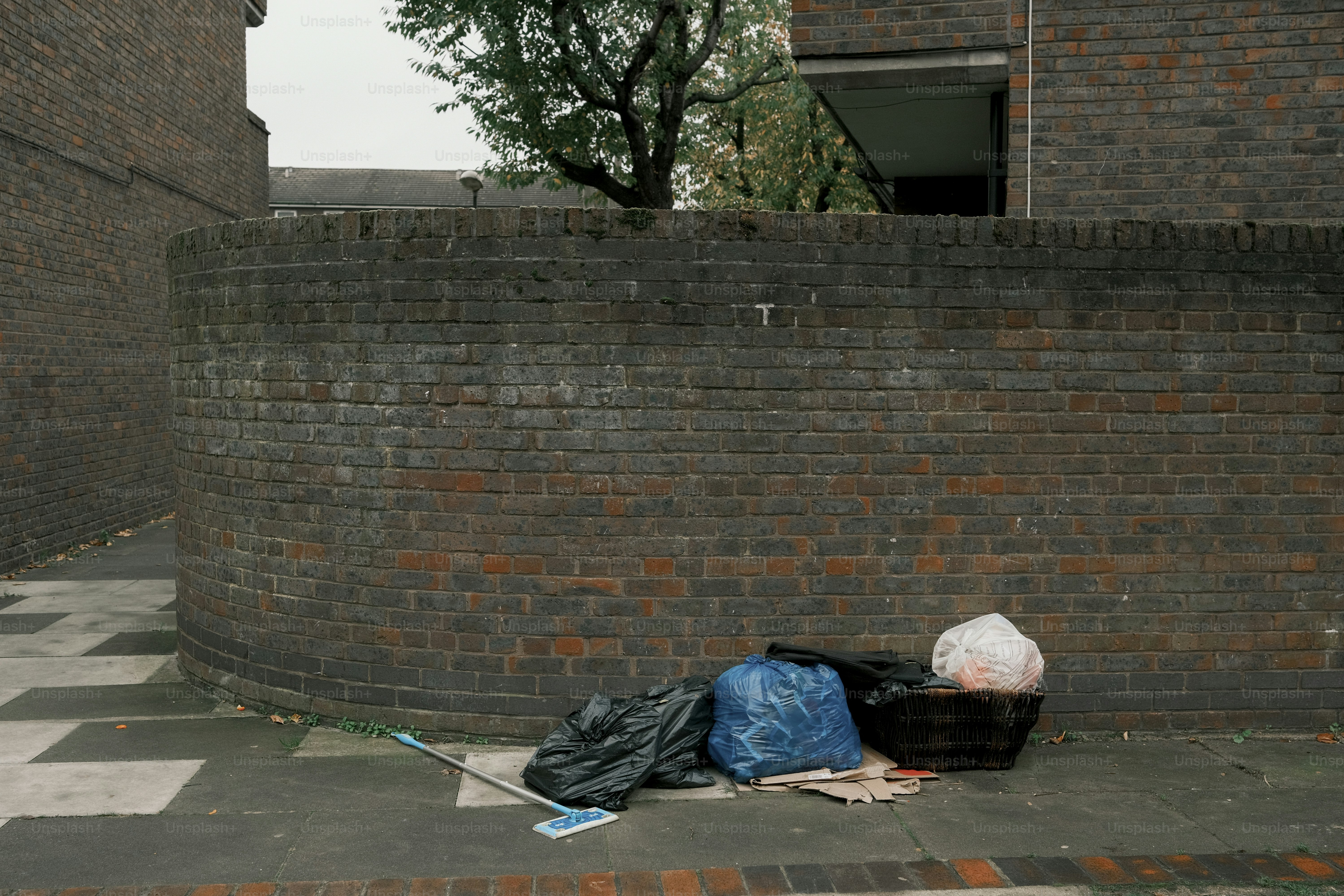 A person laying on the ground next to a brick wall photo – Neglected ...