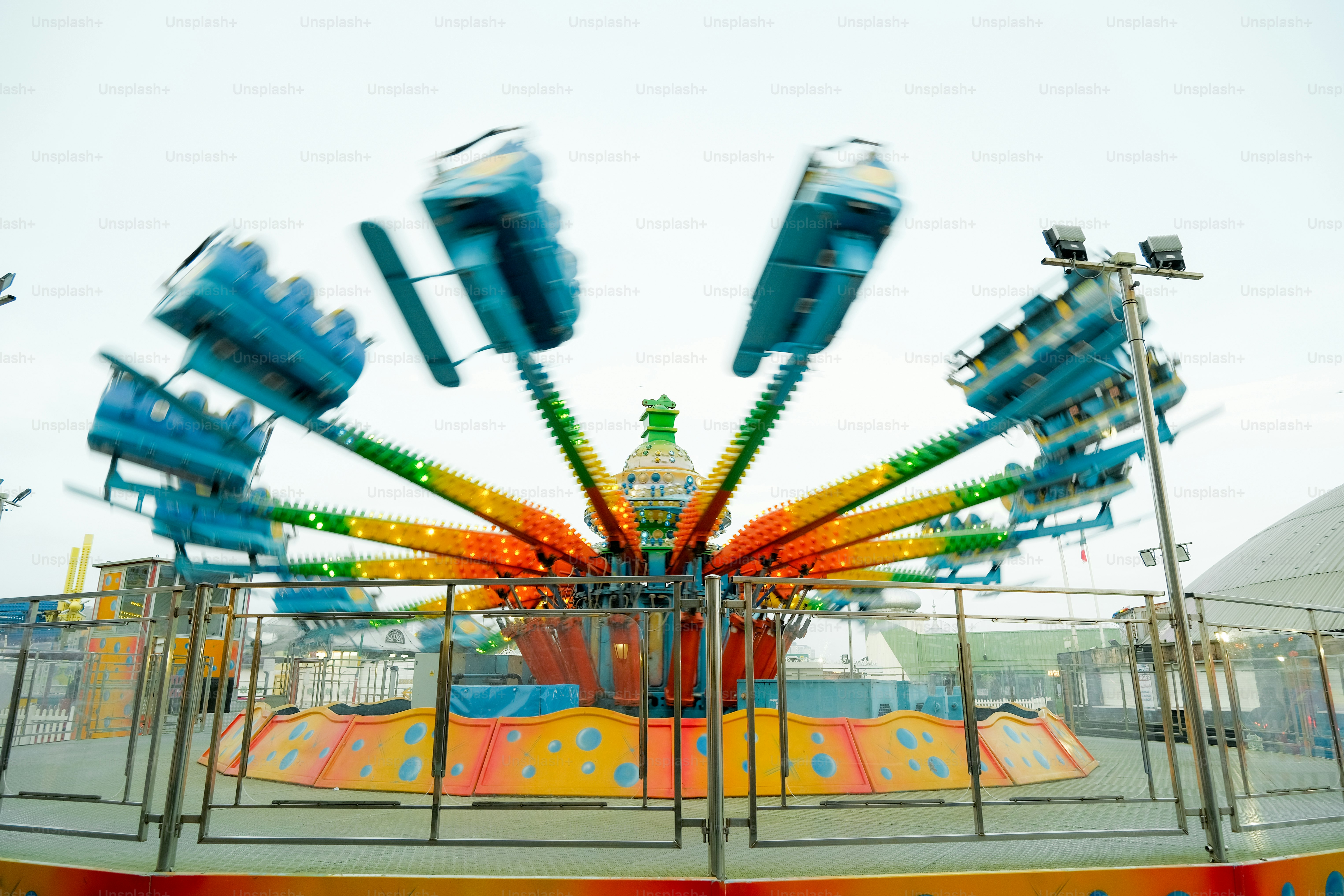 A carnival ride with blue and yellow lights photo – Amusement park ...