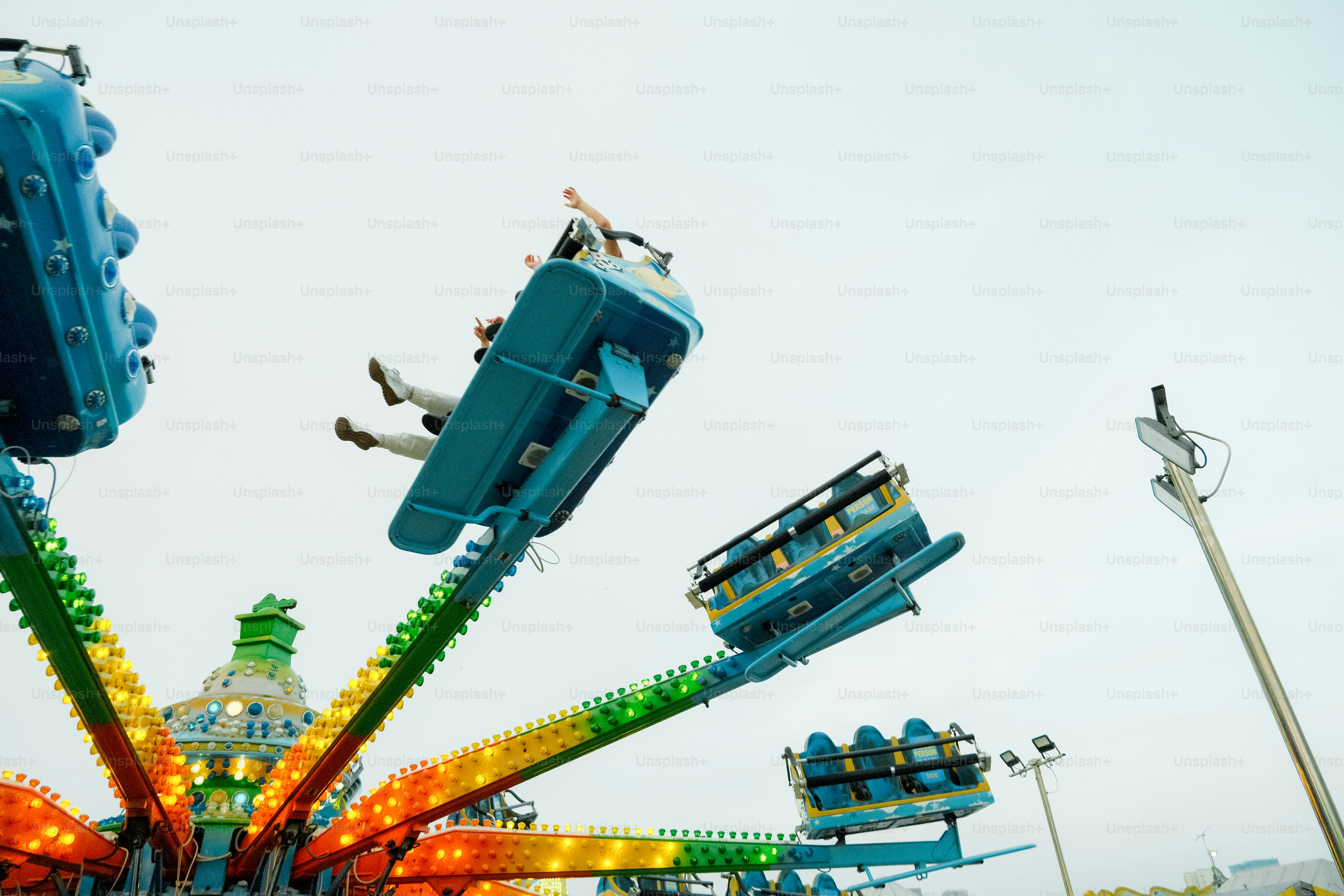 A carnival ride with people riding on top of it photo – Amusement park ...