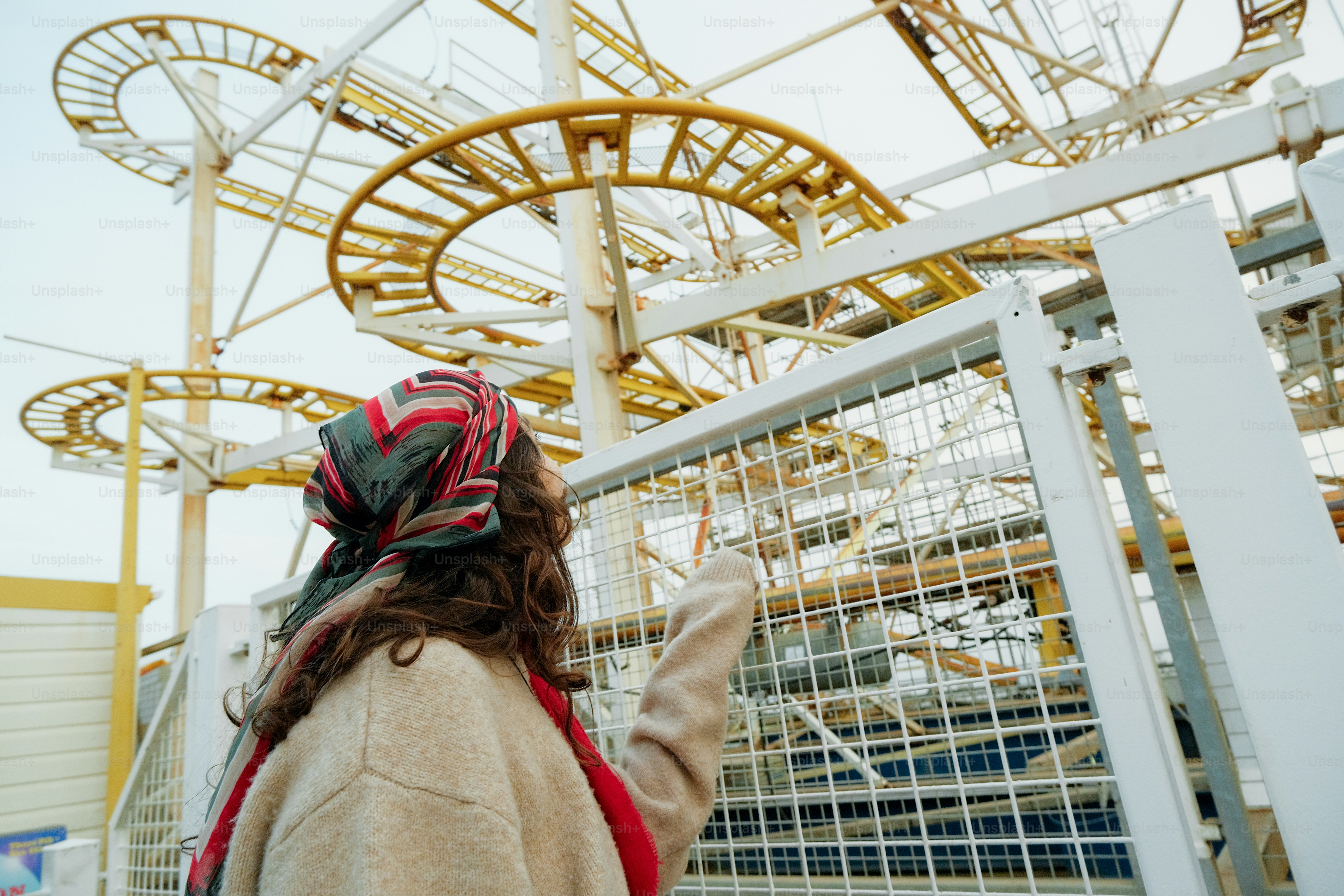 A woman standing in front of a roller coaster photo – Amusement park ...