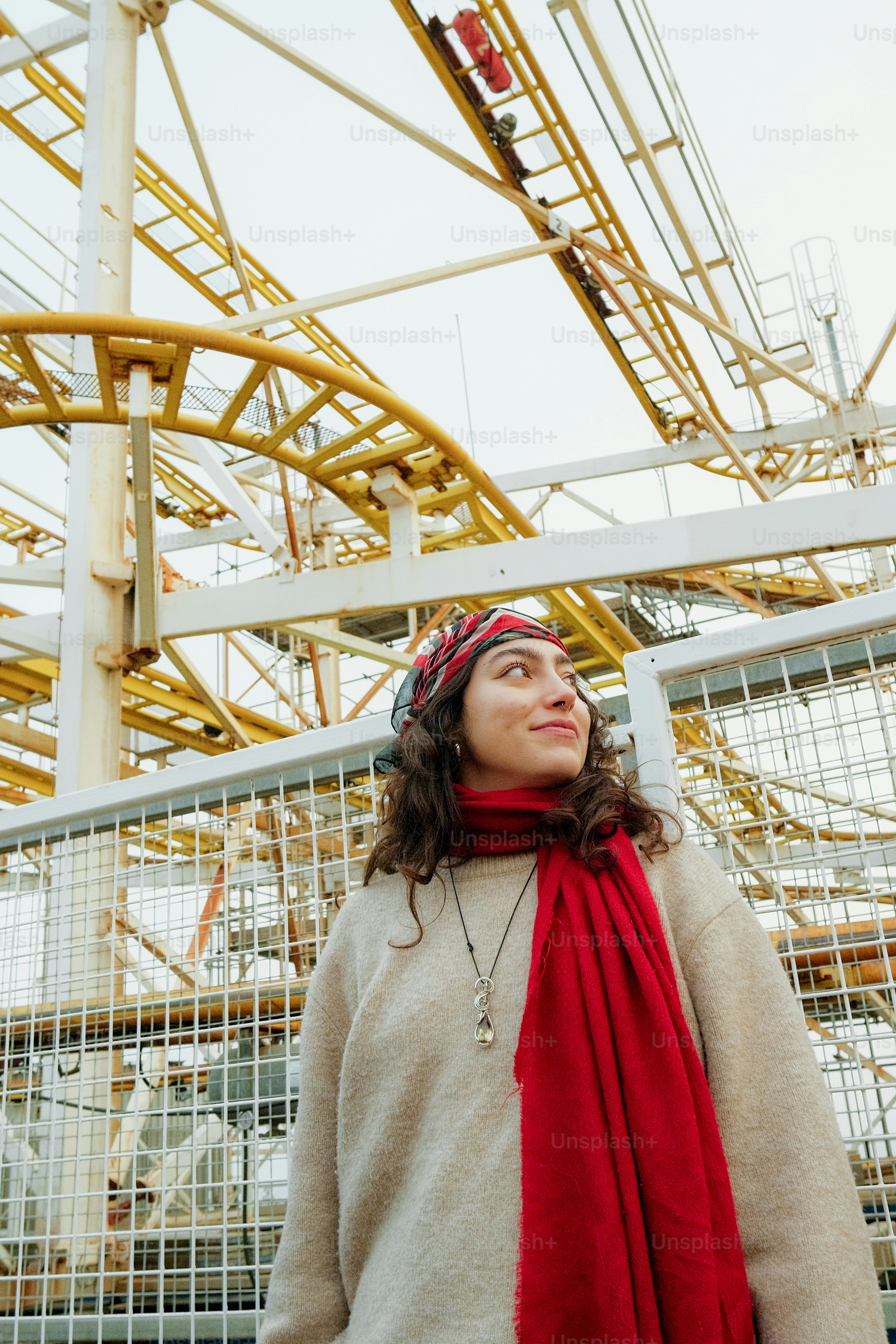 A woman standing in front of a roller coaster photo – Amusement park ...