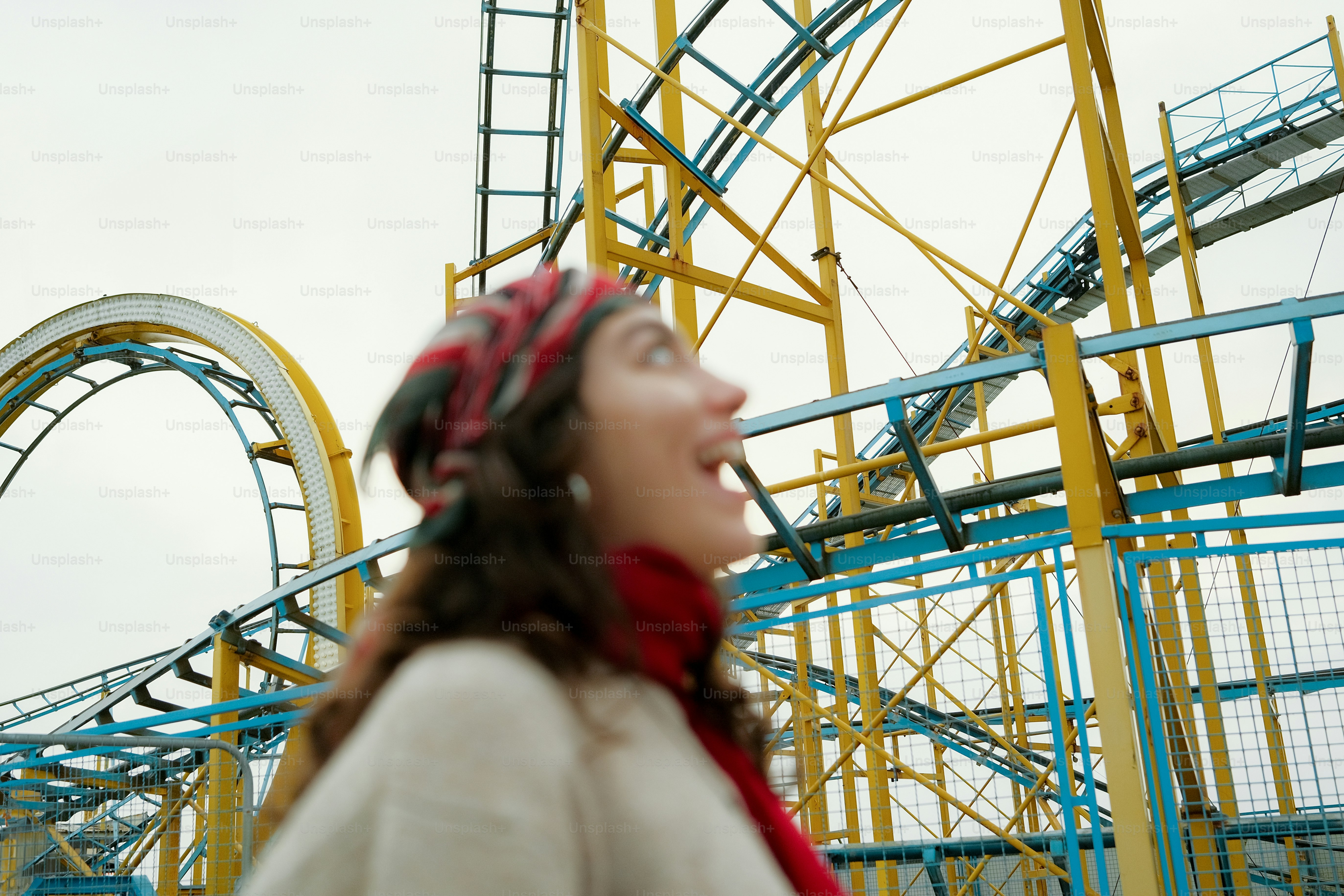 A woman standing in front of a roller coaster photo – Amusement park ...
