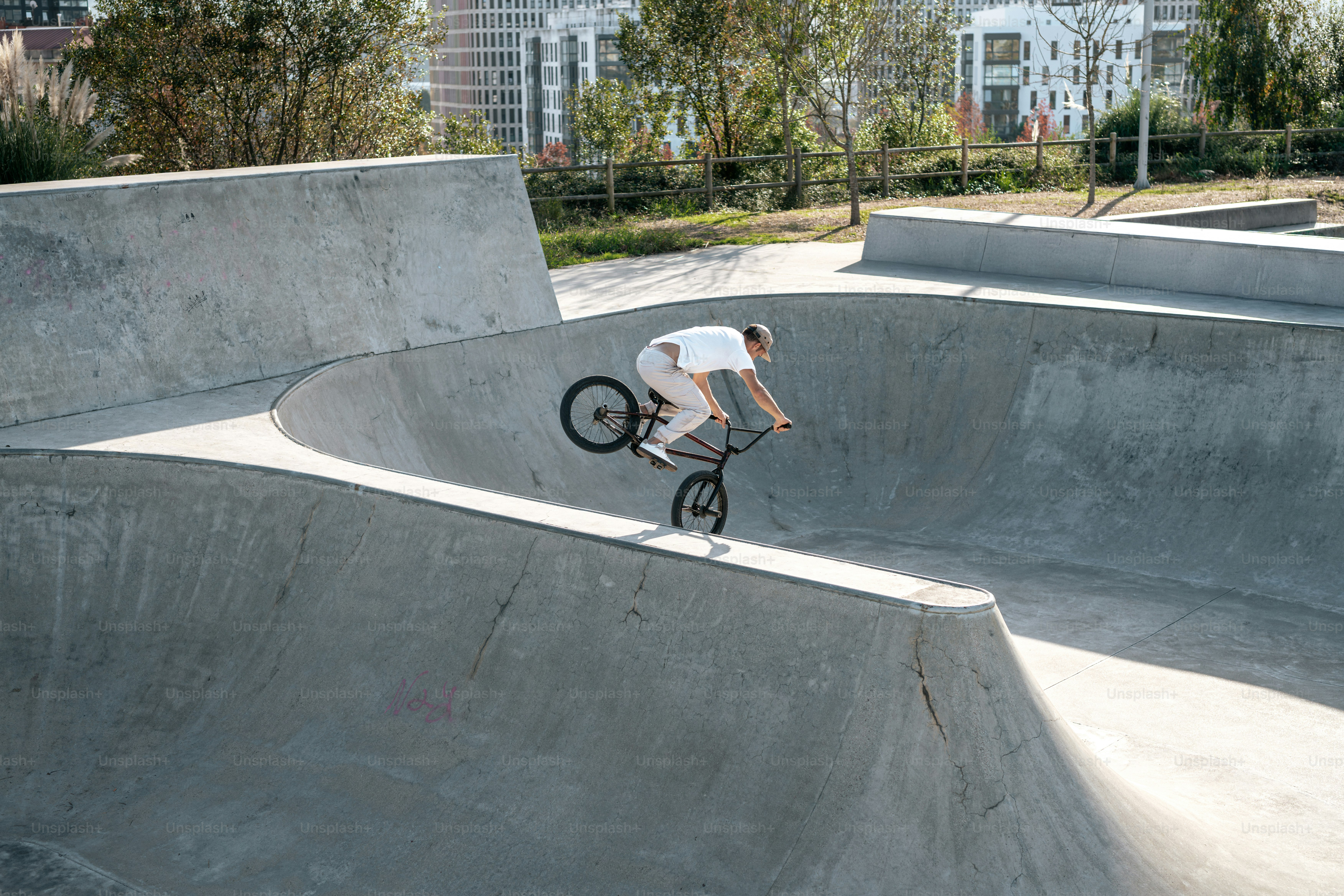 A man riding a skateboard up the side of a ramp photo – Bike trends ...