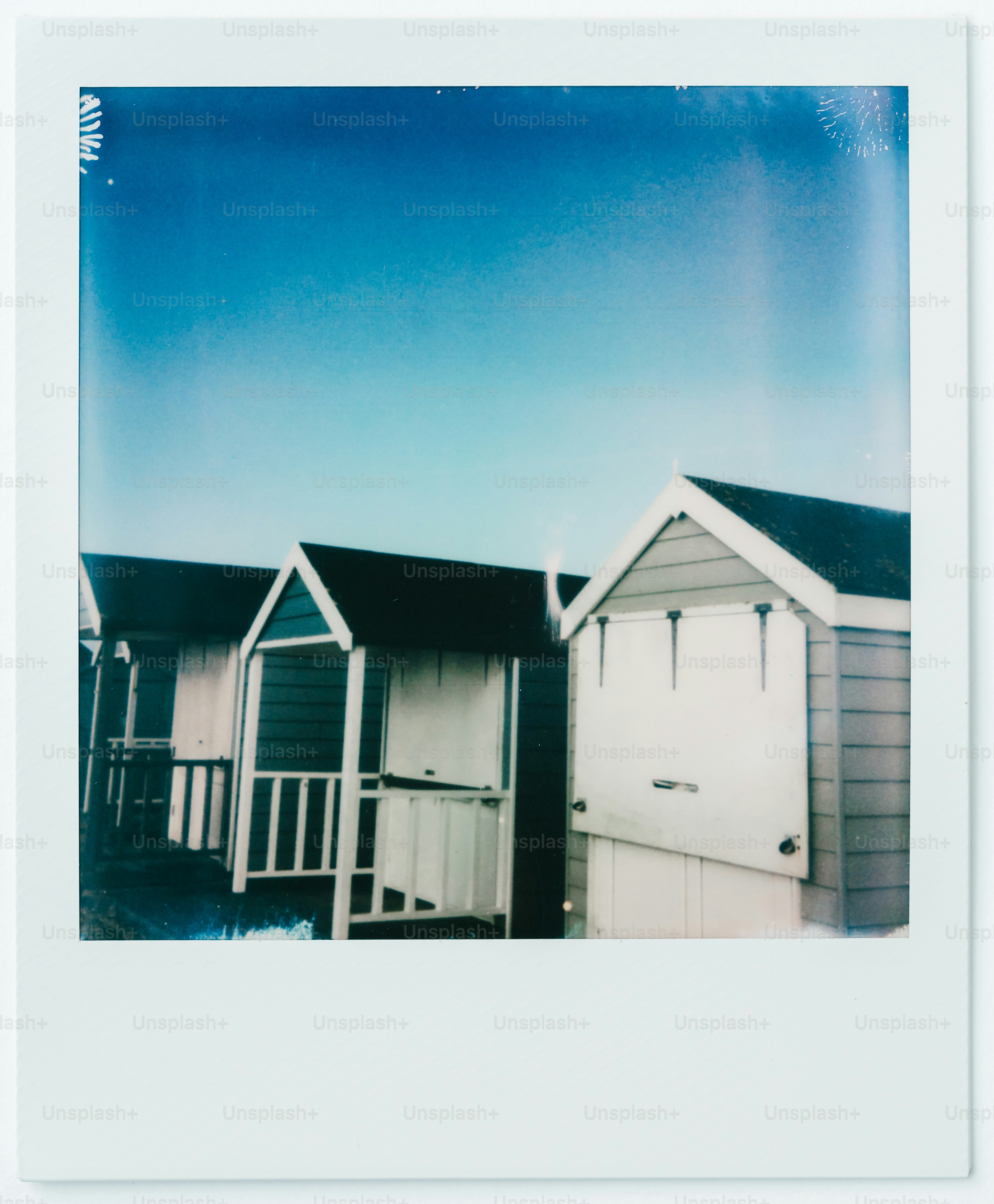 A group of beach huts sitting next to each other photo – Beach Image on ...