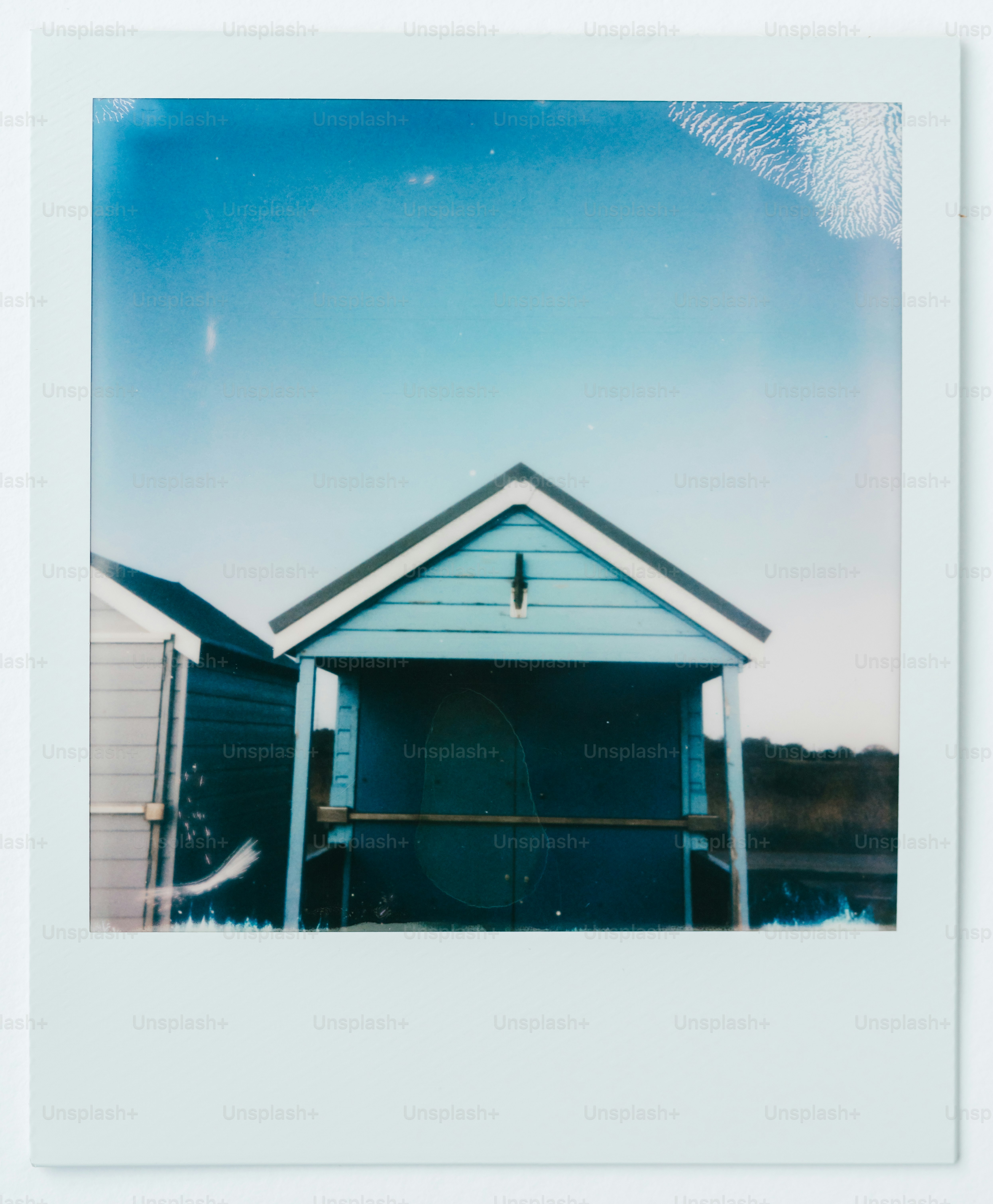 Une photographie polaroid d’un bâtiment bleu photo – Image de Cabane de ...