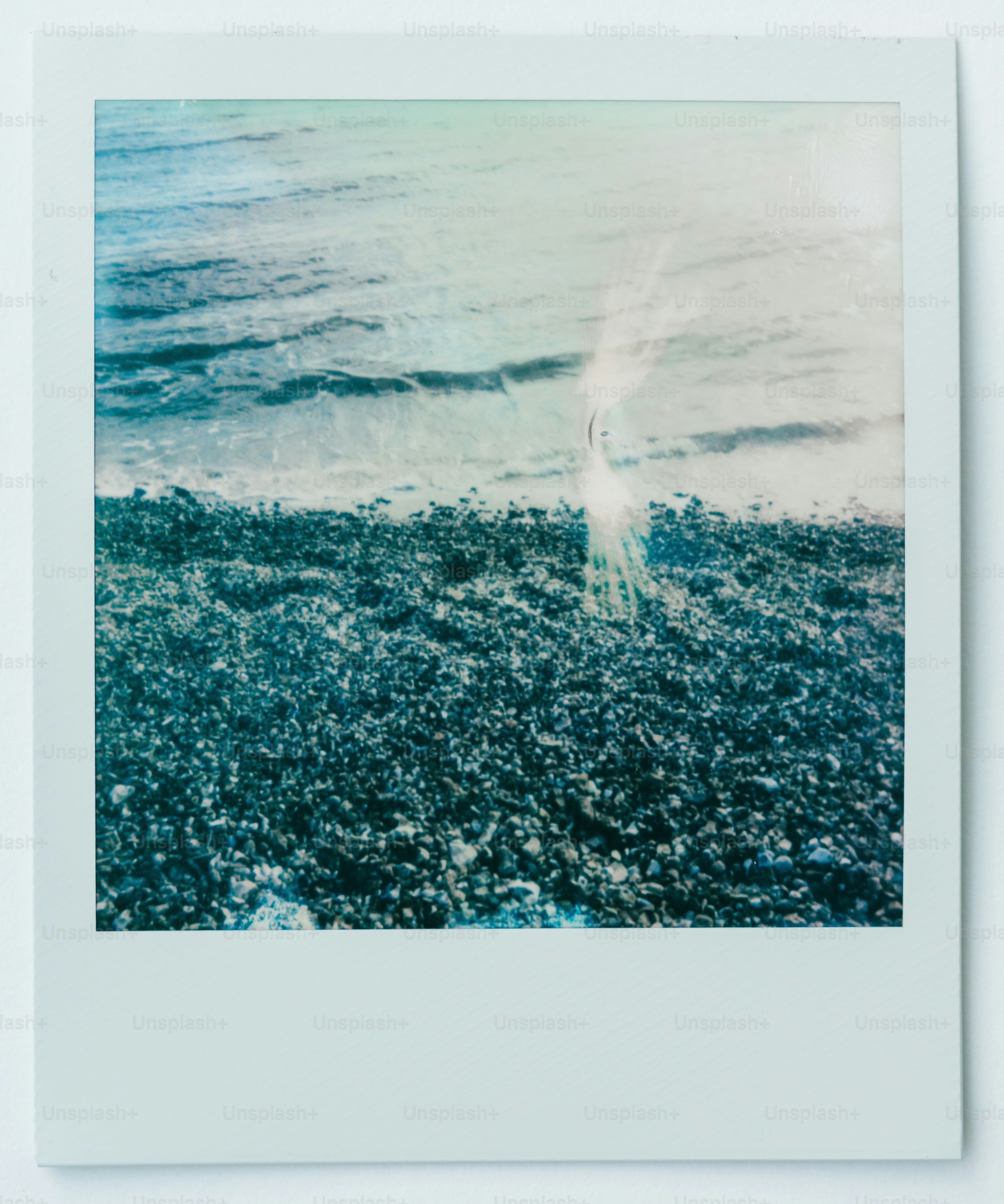 A polaroid photograph of a house with a blue sky in the background ...