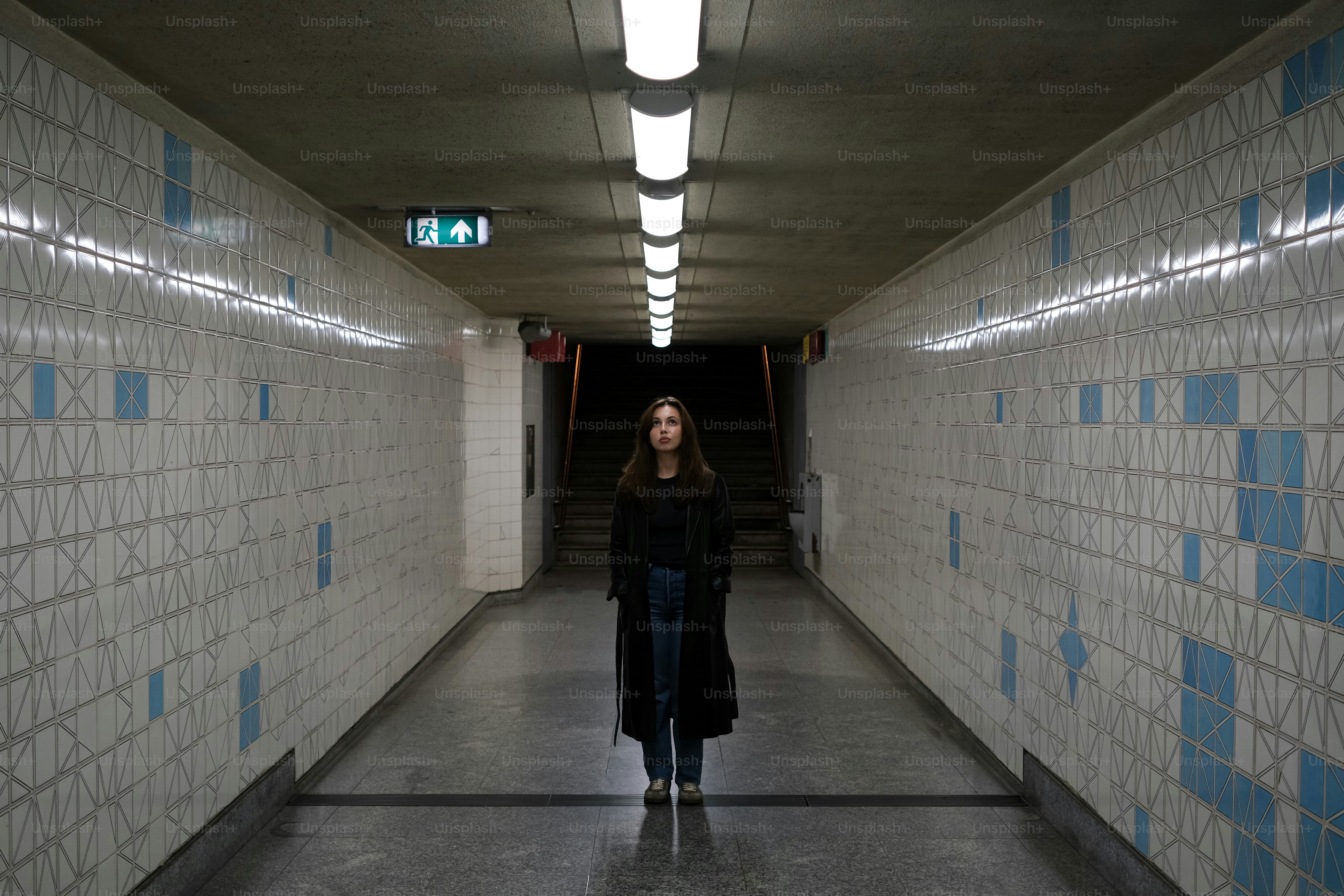 A woman is walking down a long hallway photo – City Image on Unsplash
