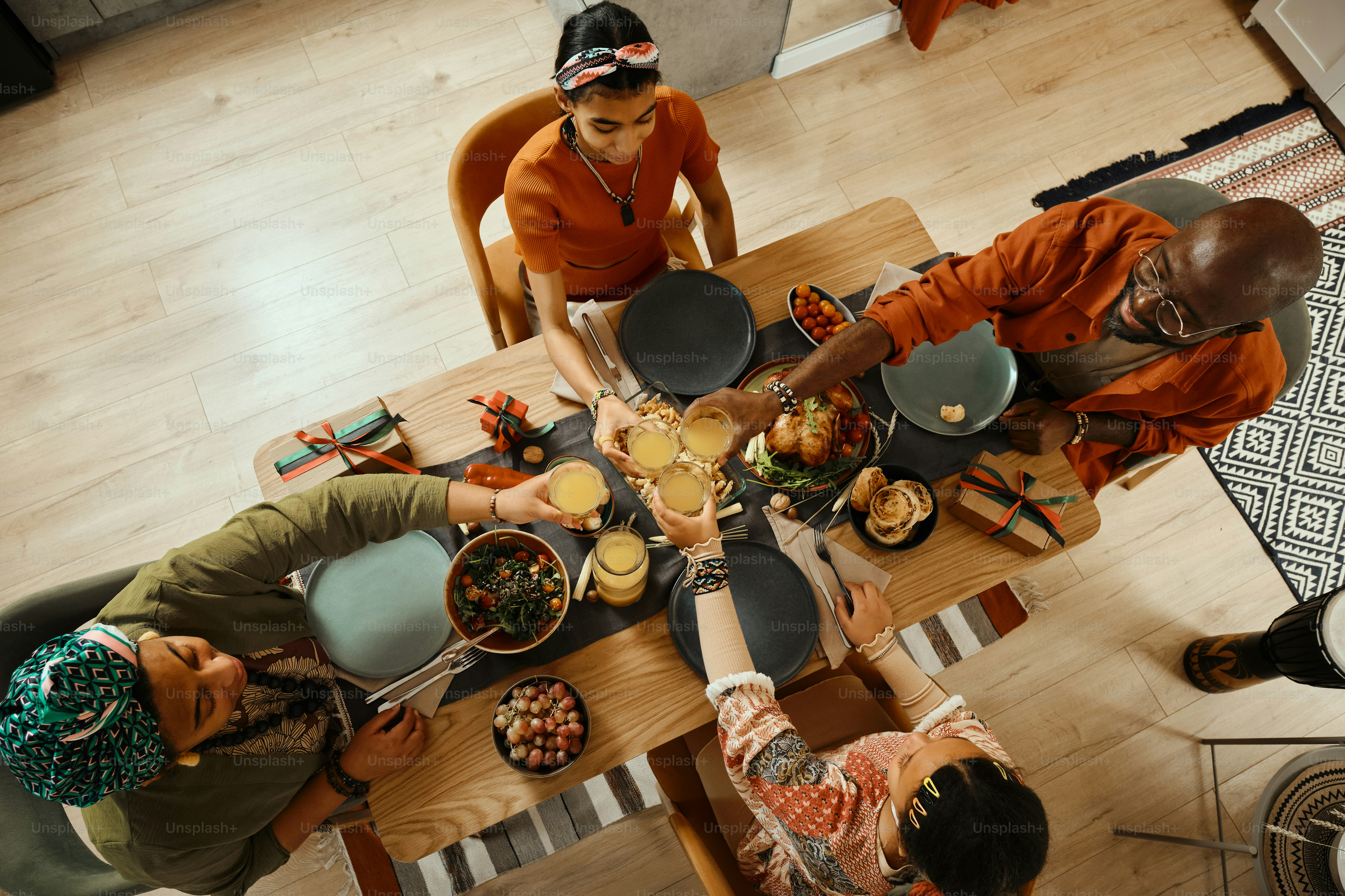 Un groupe de personnes assises autour d’une table en train de manger ...